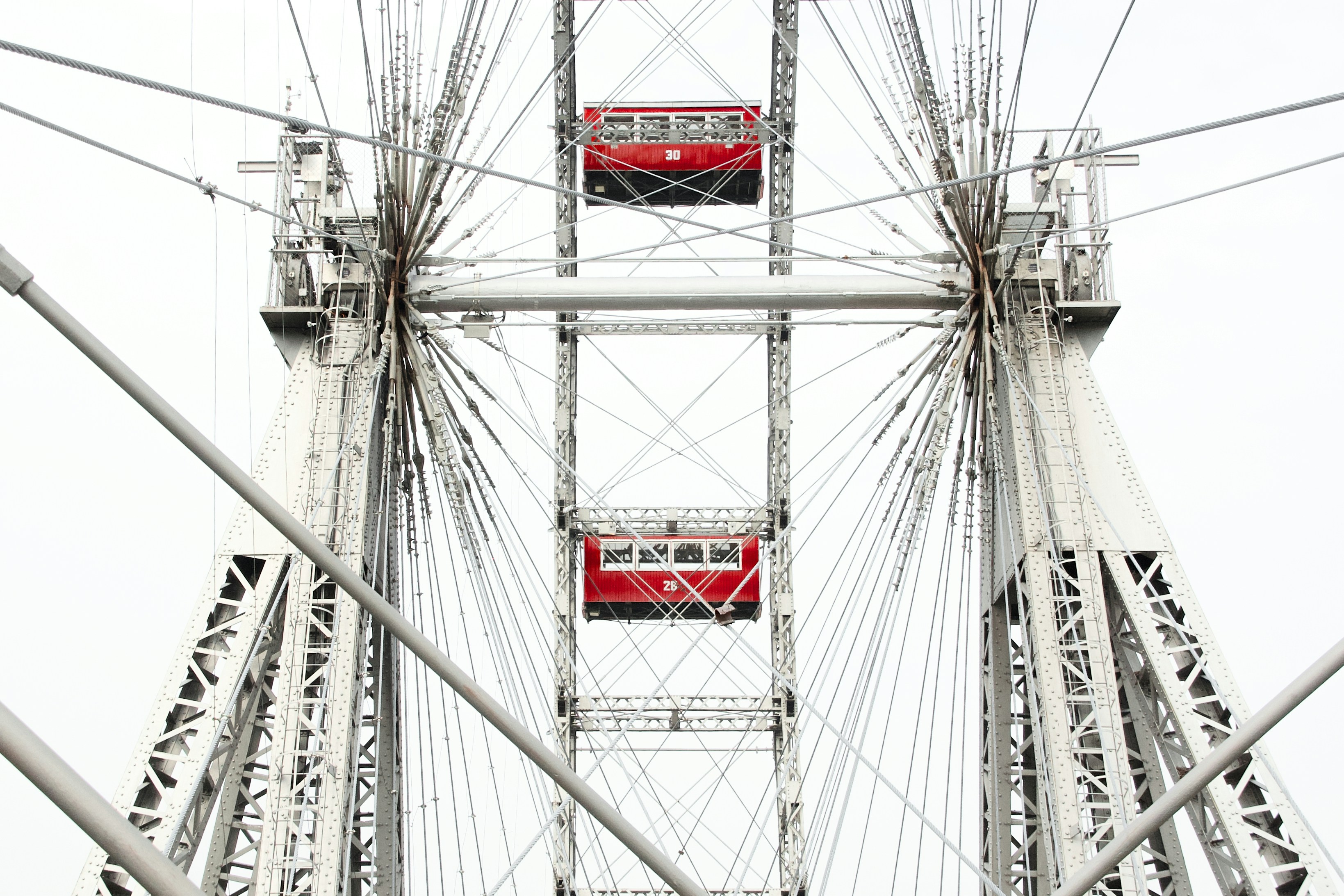 Cable Car Over the Towers: A Close-Cropped View of a Red Gondola Gripping the Steel Spire