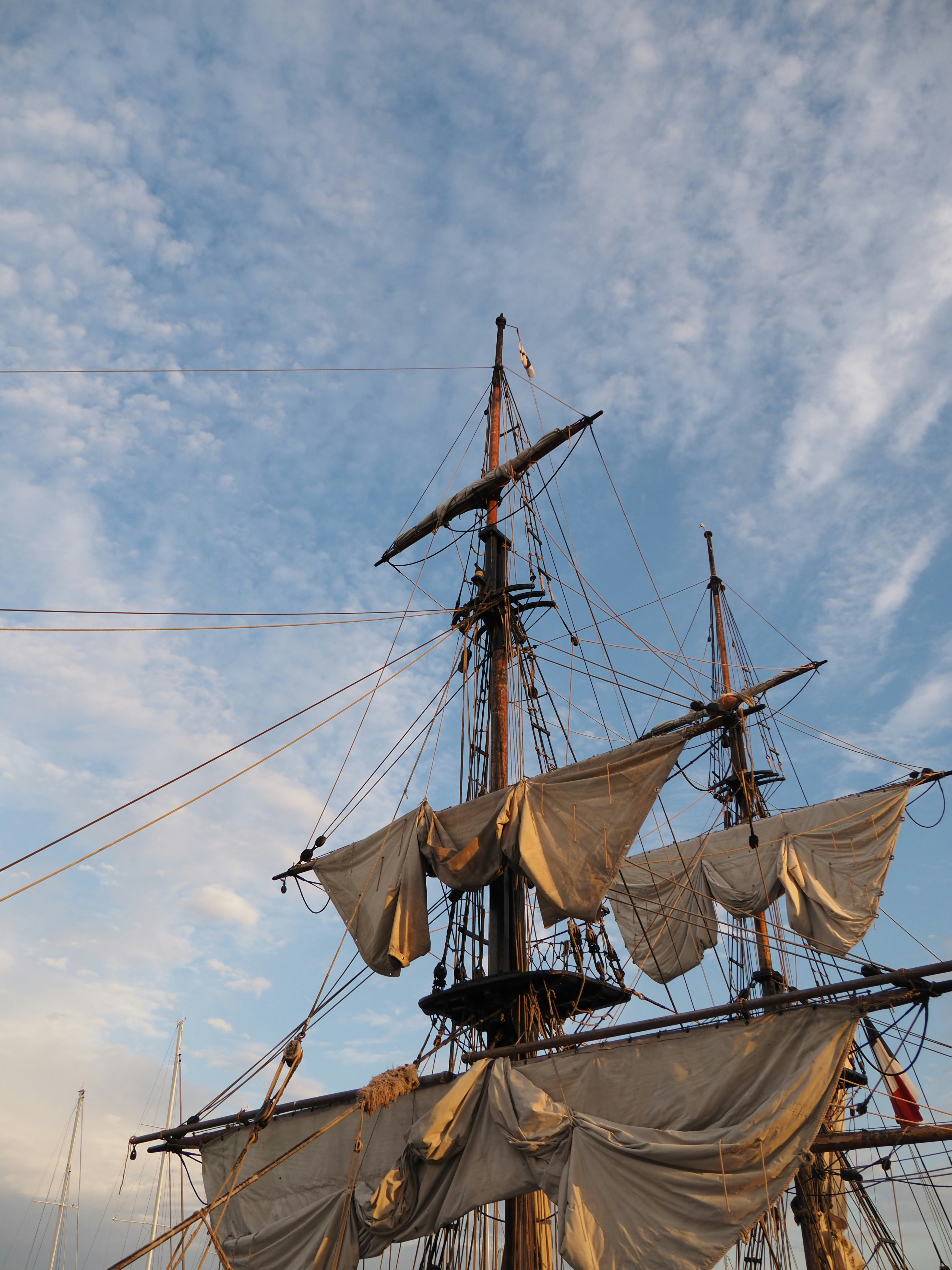 Sail and Sky: A masted silhouette under a crisp evening canvas