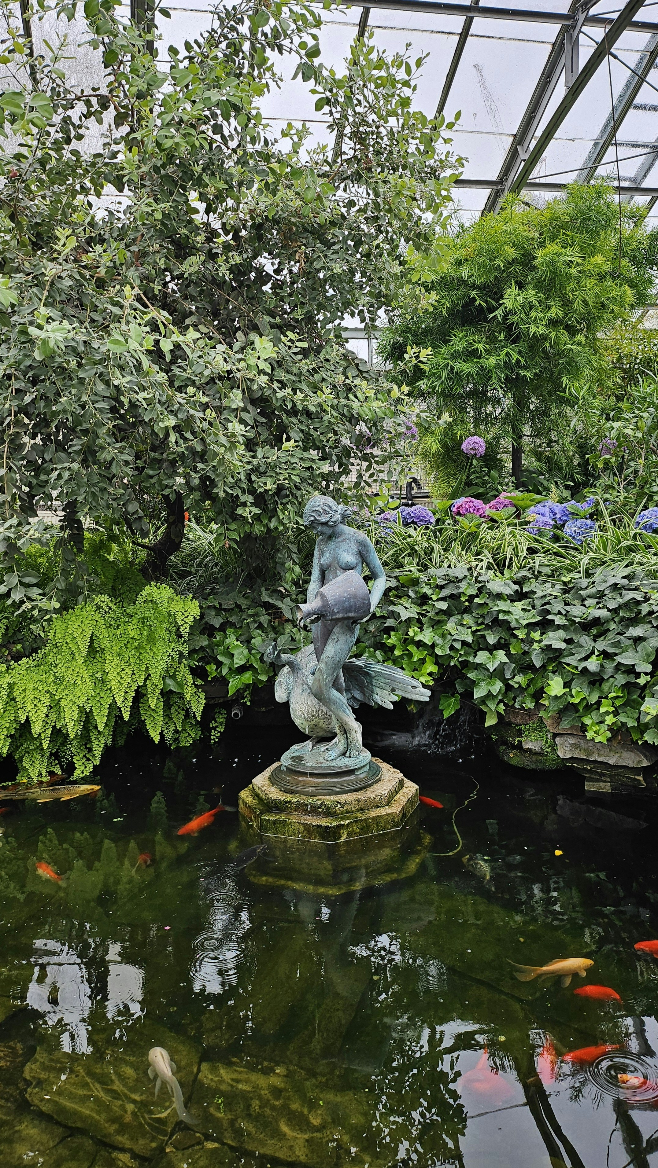 Emerald Oasis: A koi-laden pond beneath a verdant conservatory statue