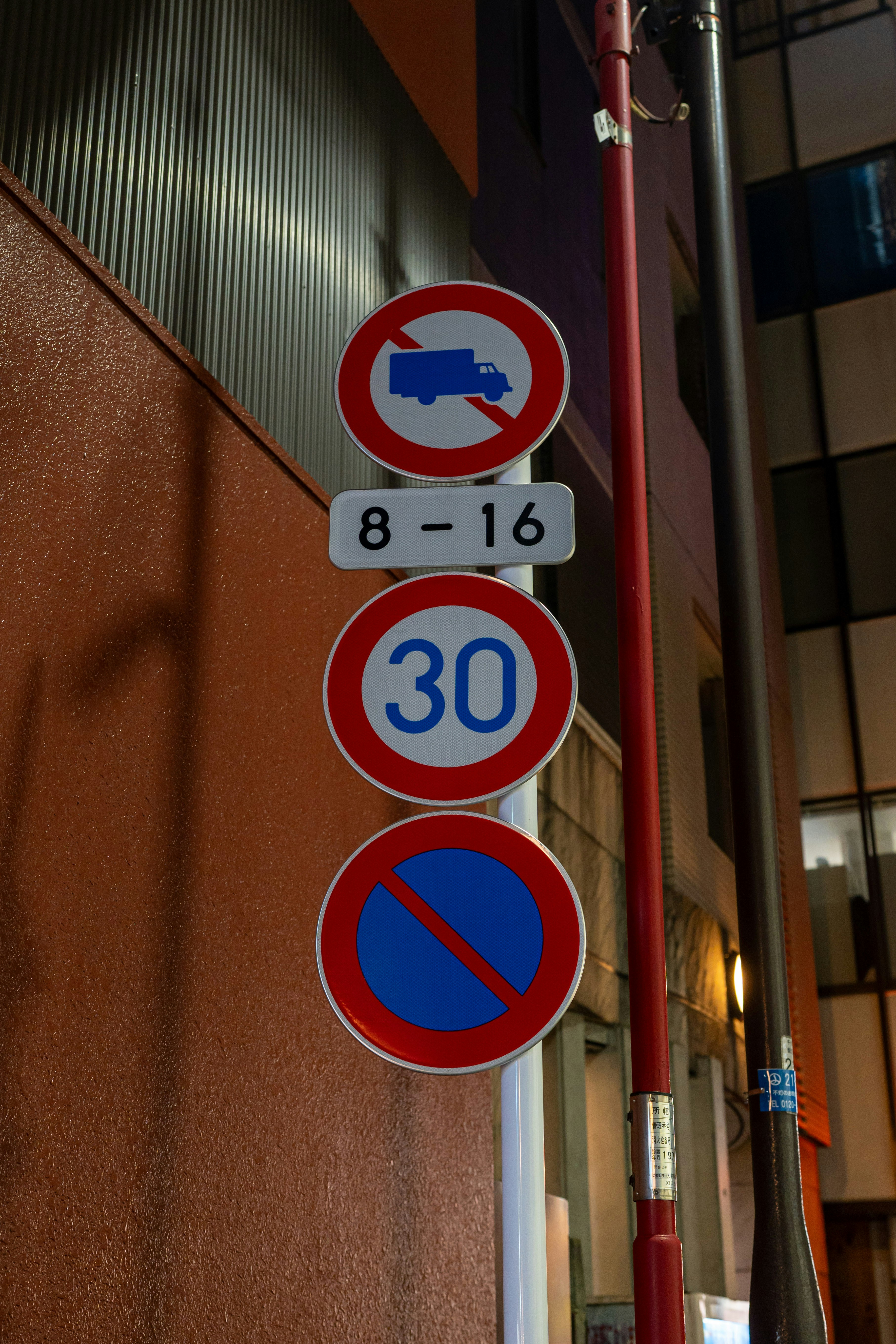 Urban Sign Stack Under Streetlight: A Vertical Timeline of Traffic Rules