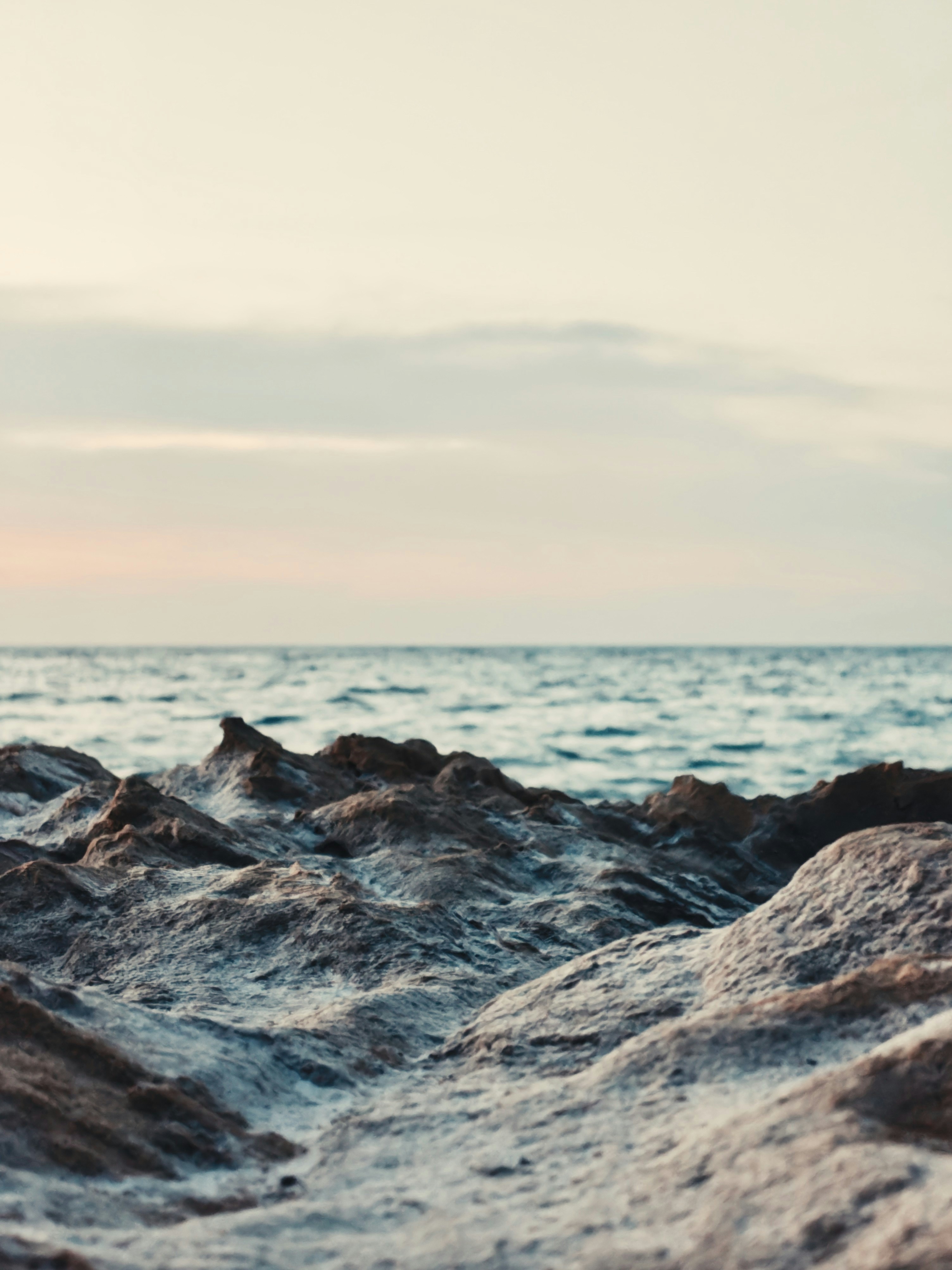 Rough Seas at Dusk: Rugged Shoreline Meeting a Quiet Horizon