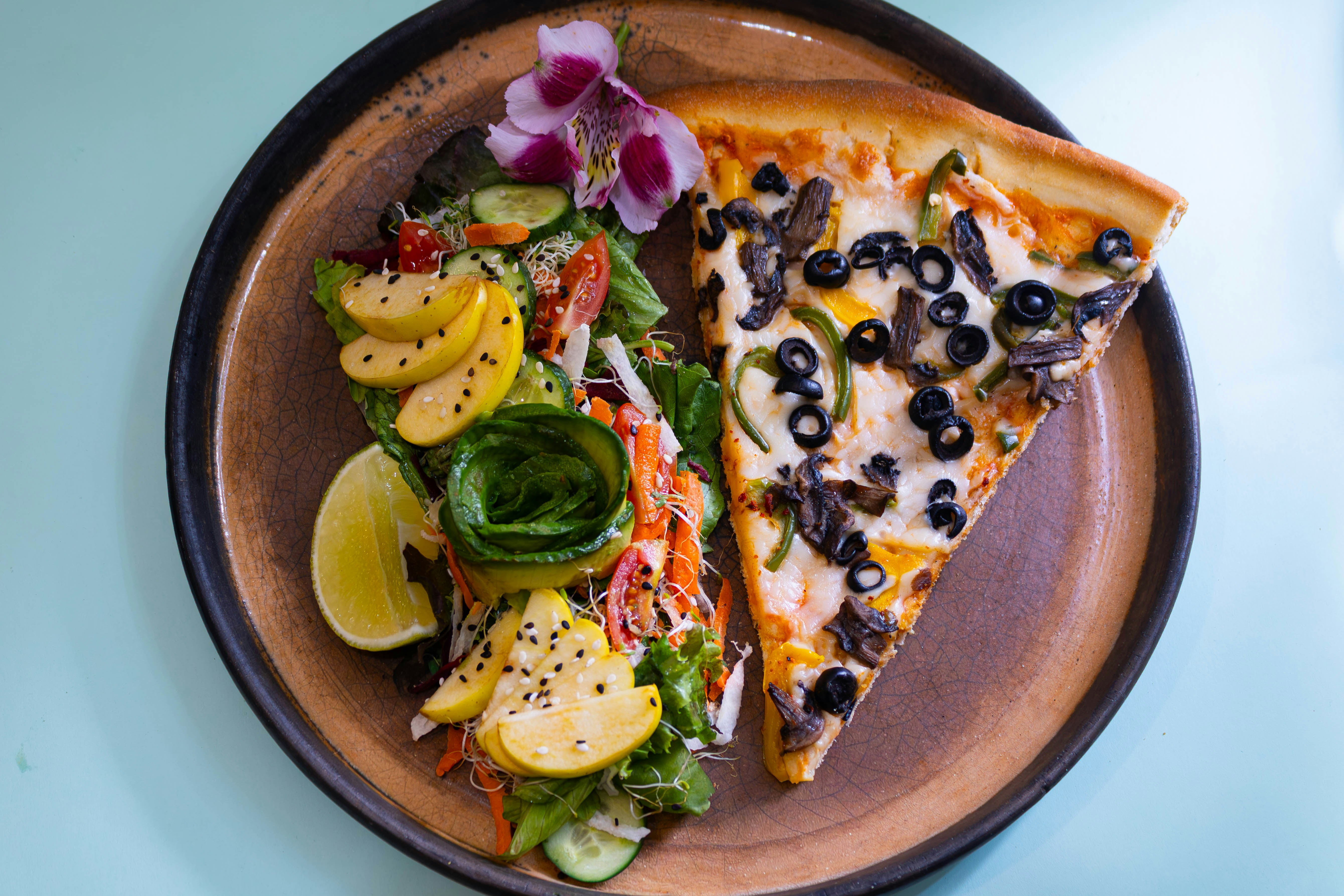 Sliced Pizza and Fresh Salad on a Rustic Plate