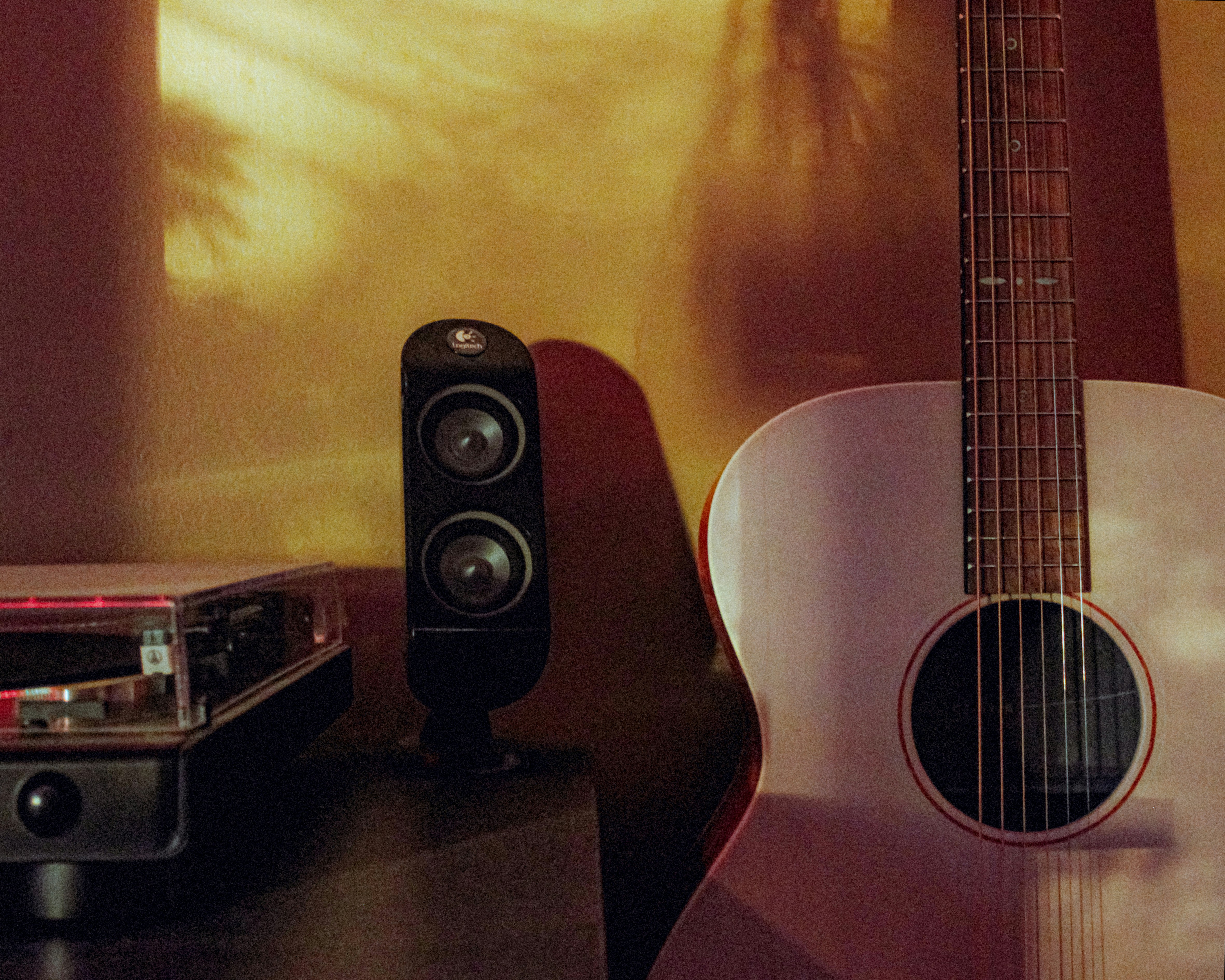 Acoustic Guitar and Mini Speaker Nestle by Dim Ambient Light