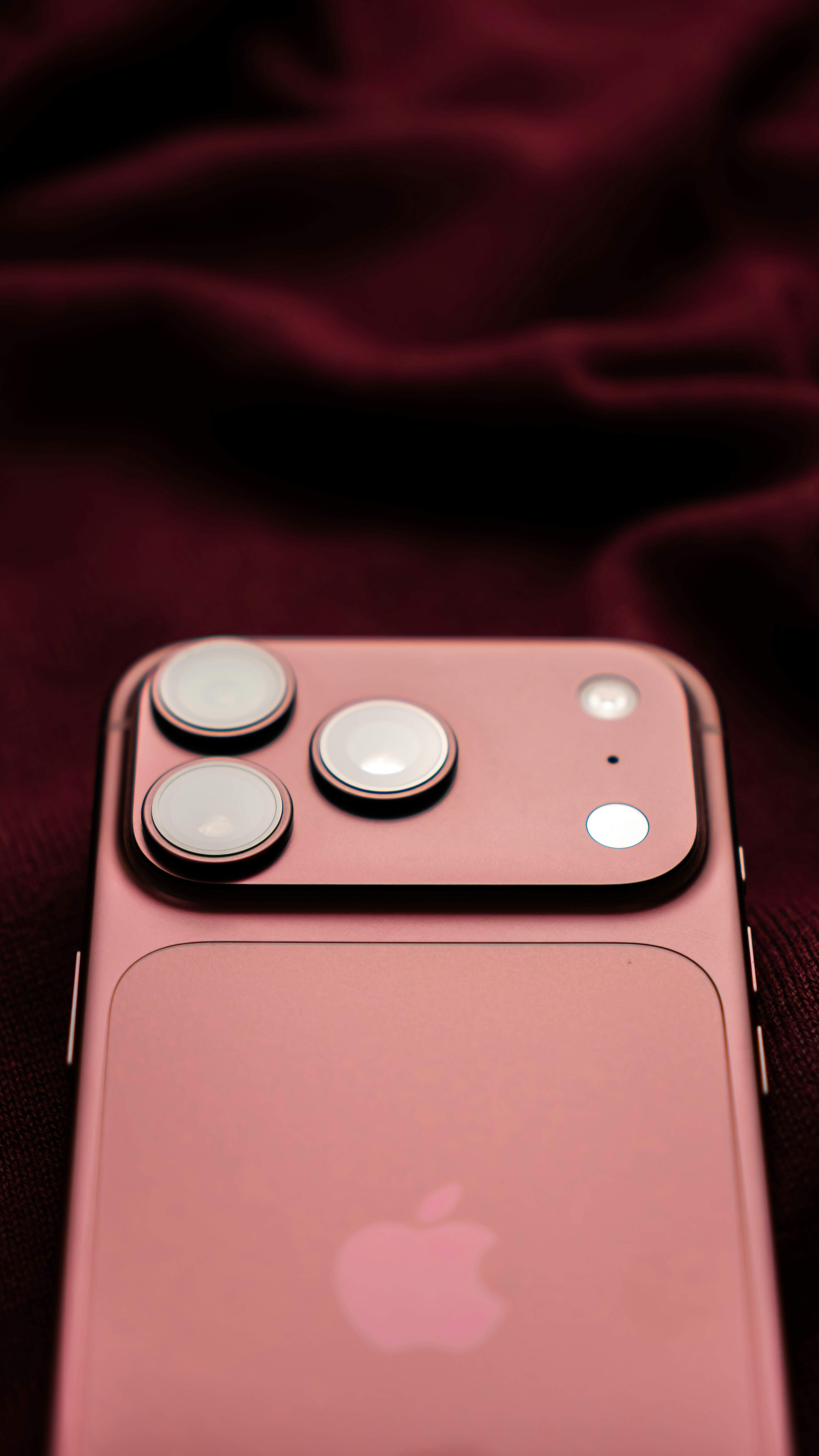 Rose-Tinted Lens: The iPhone Pro camera module in soft spotlight
