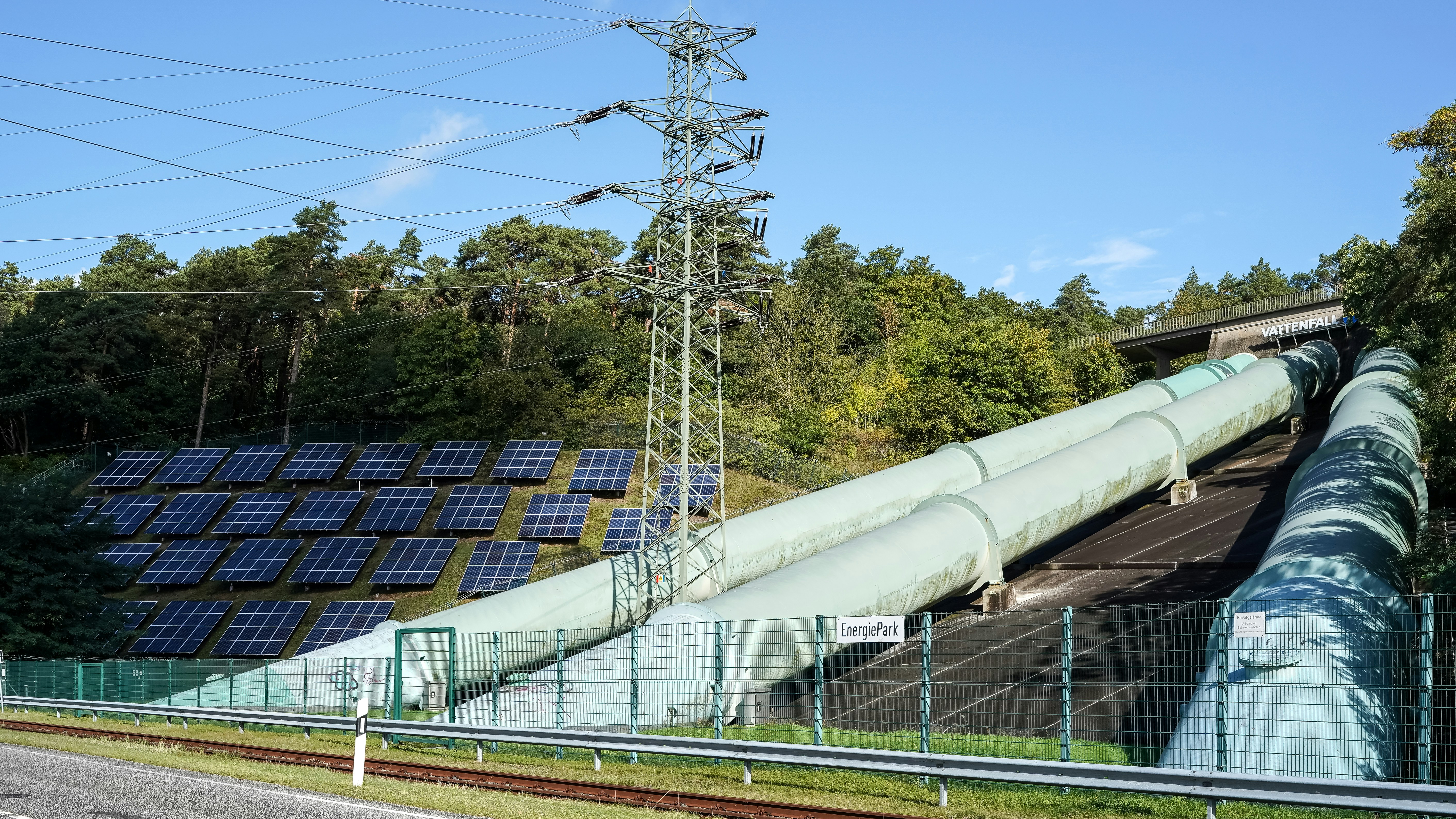 Industrial Skyline: Solar Arrays Beside a Concrete Conduit