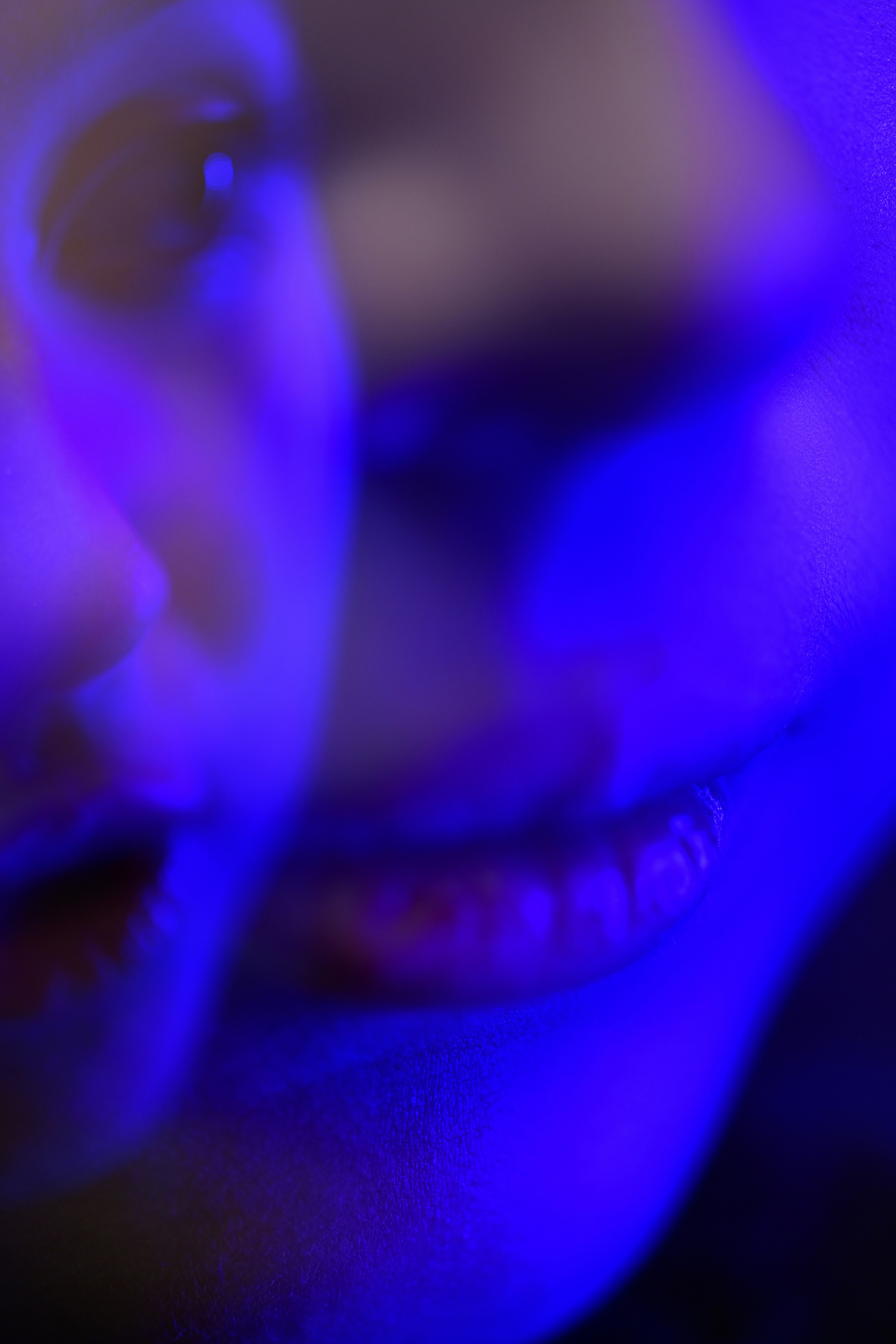 Blue-glow Portrait: A Blurred Close-Up of a Smiling Face