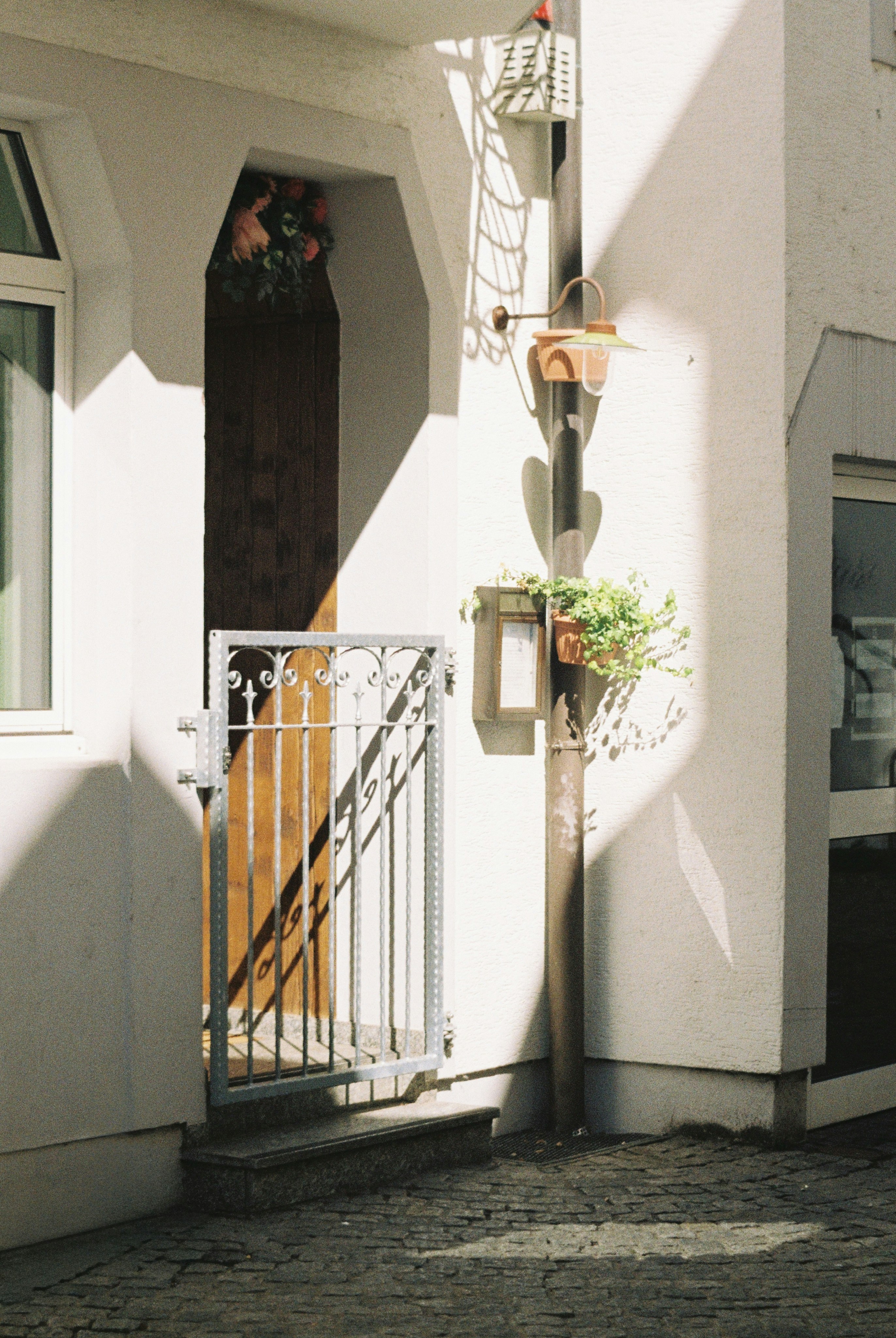 Sunlit Entrance: A Quiet Corner of a White-Walled Street