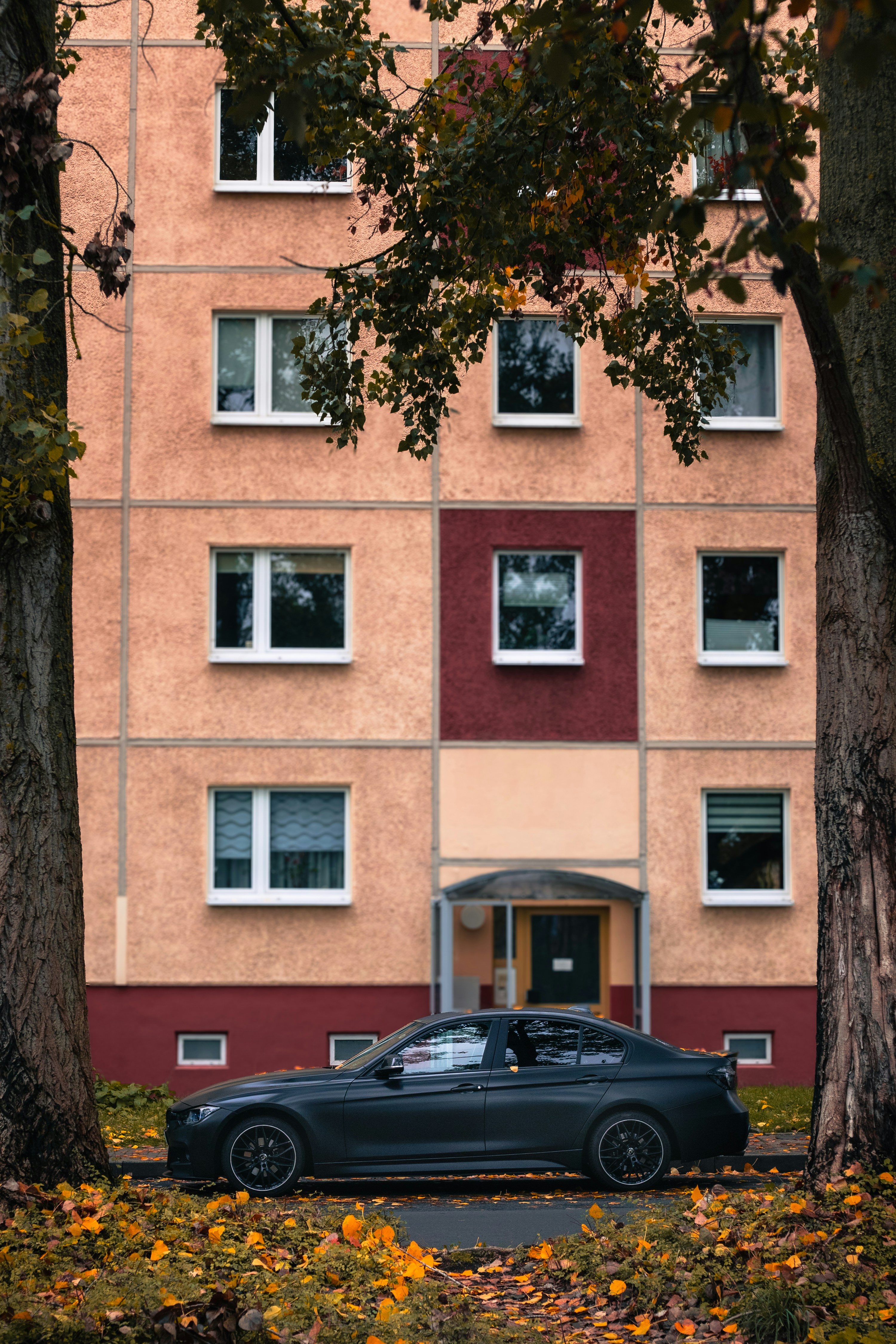 Midwest Apartment Lines Guarded by a Noir-Blue Sedan