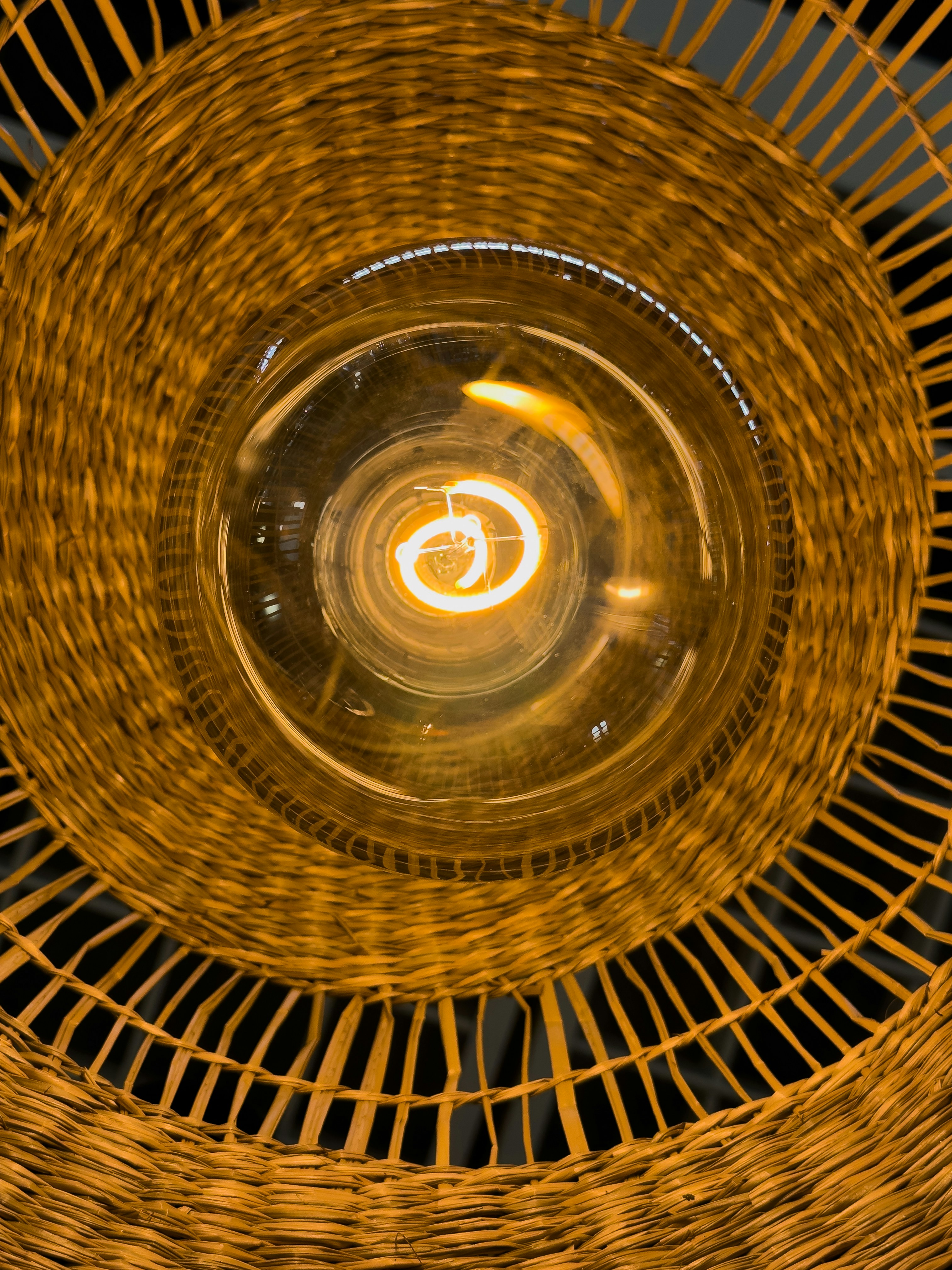 Golden Vortex: A Lamp's Spiral in a Woven Canopy