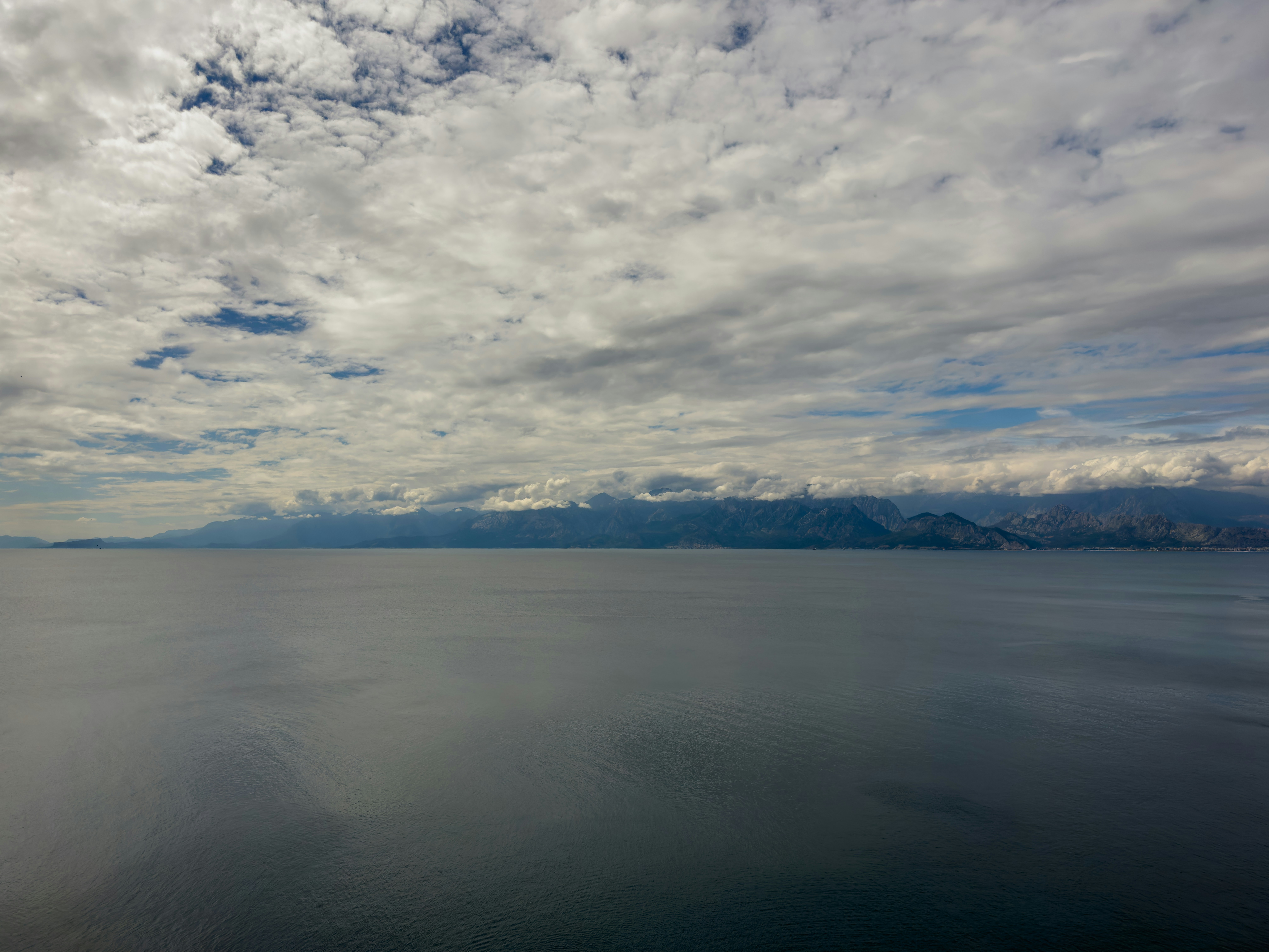 Ethereal Horizon: Clouds Hover Over Quiet Blue Seas
