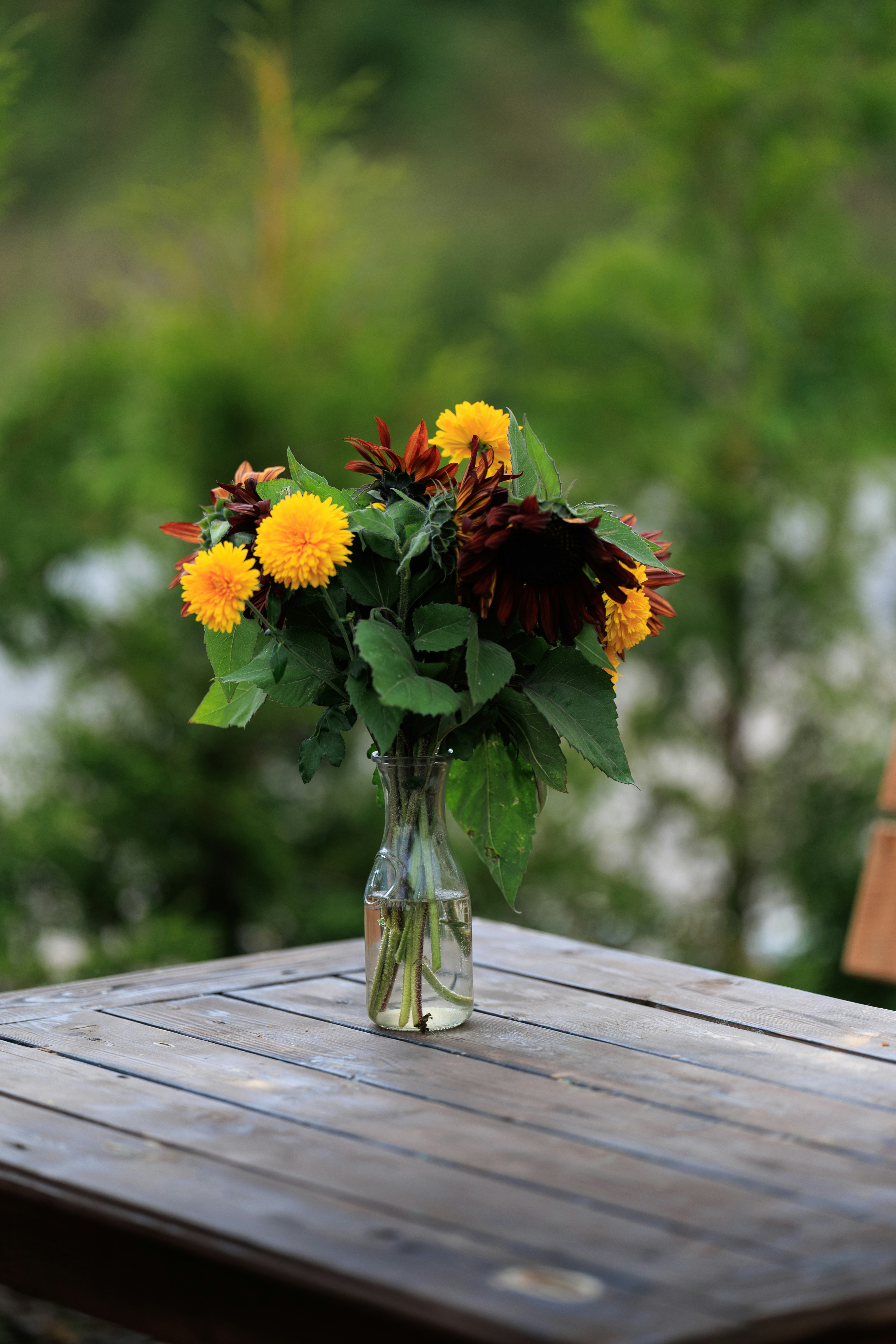Sunlit Bouquet in a Glass Vase on a Weathered Table