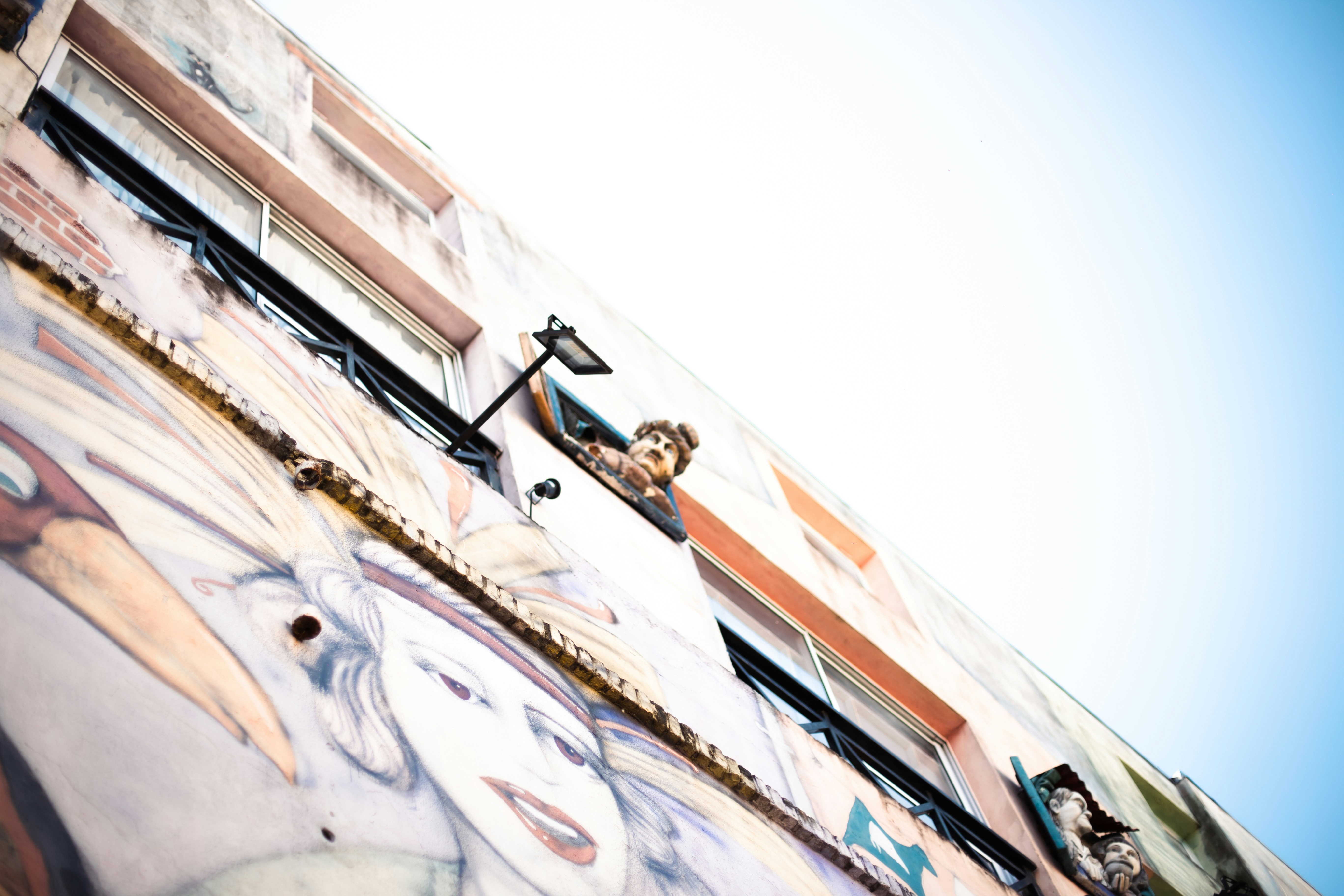 Graffiti-clad building lean-in: a rooftop portrait under bright sky