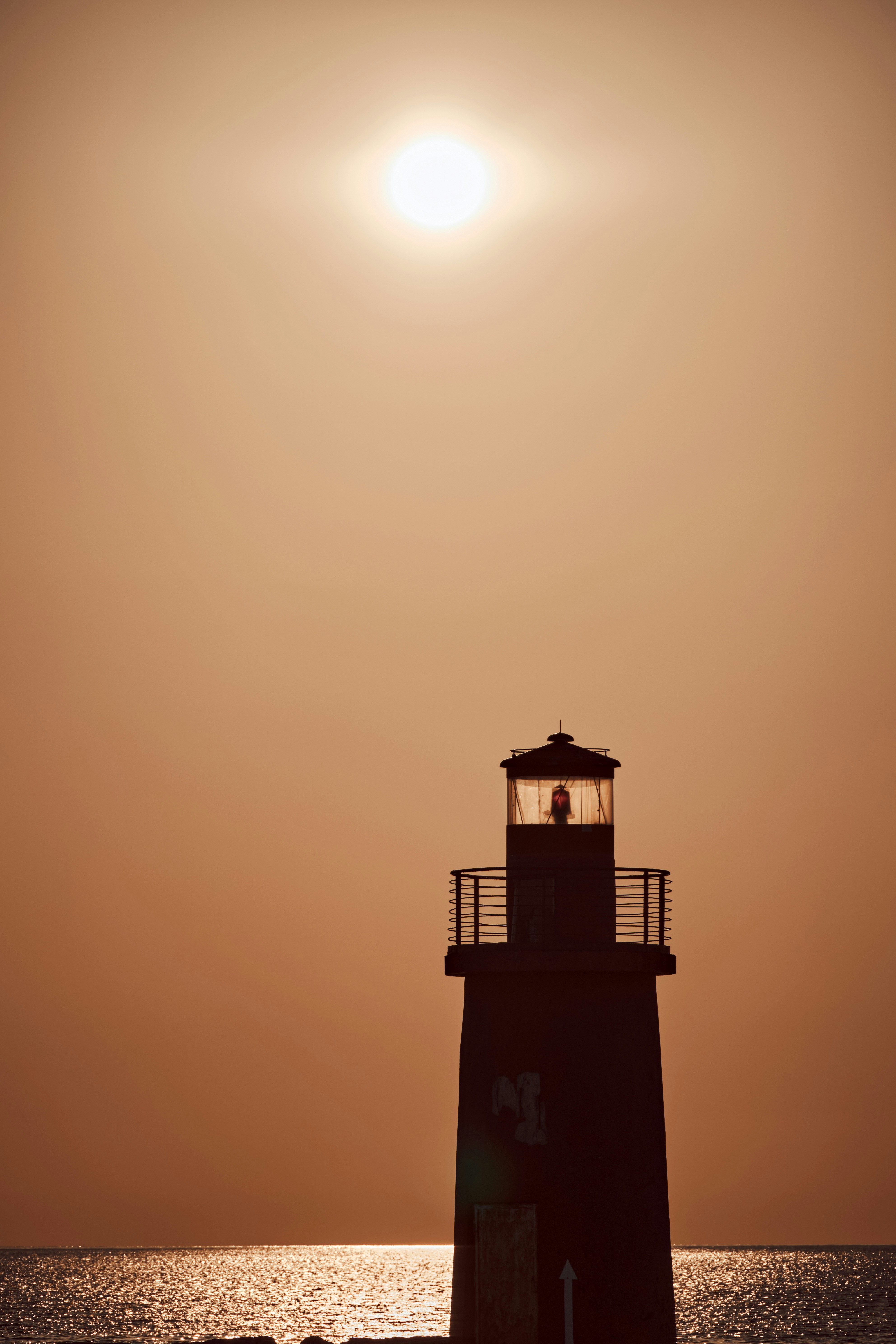 Silhouette of a Lighthouse Against a Golden Dusk