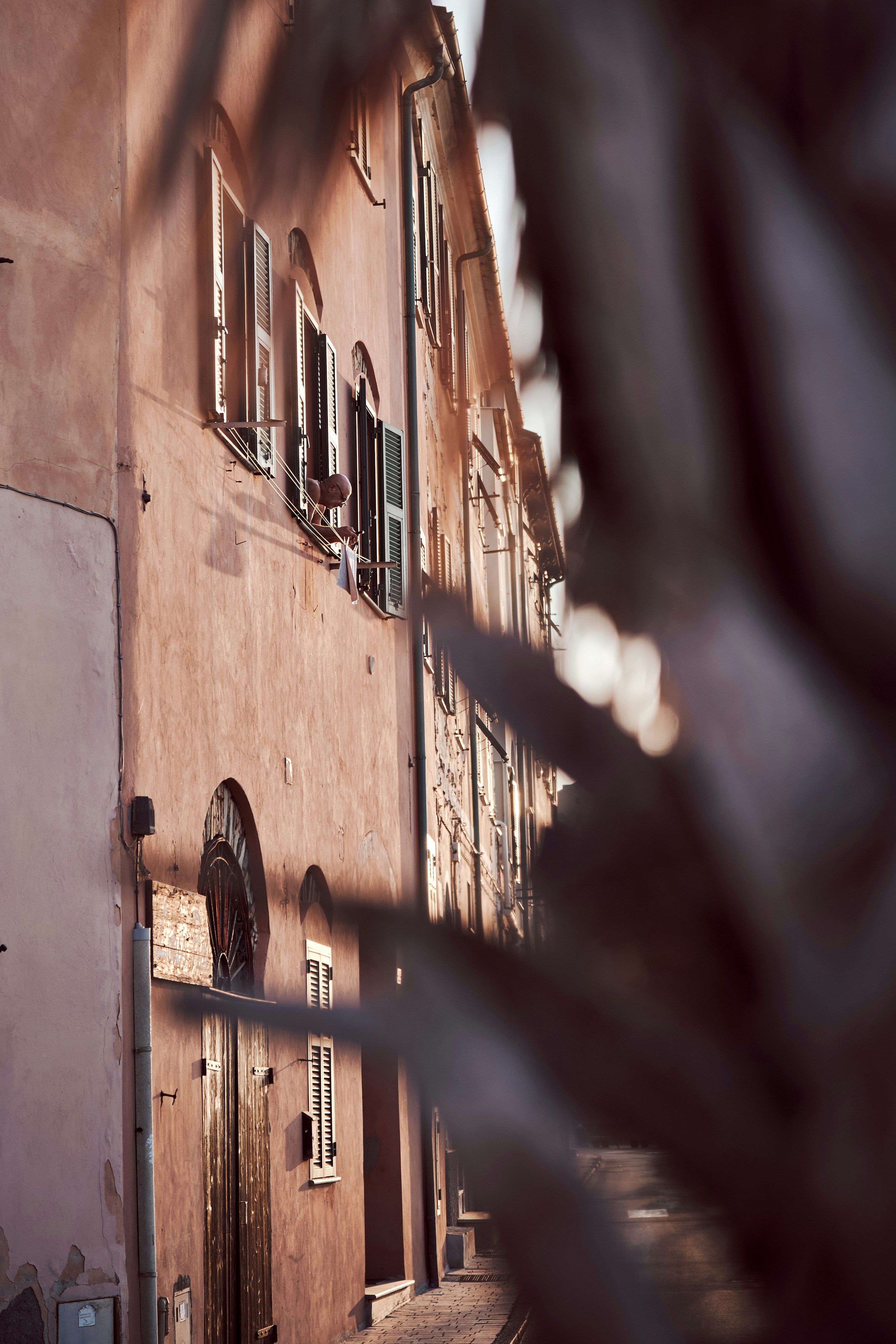 Sunlit Facade Veil: A Quiet Alley Between Shuttered Windows