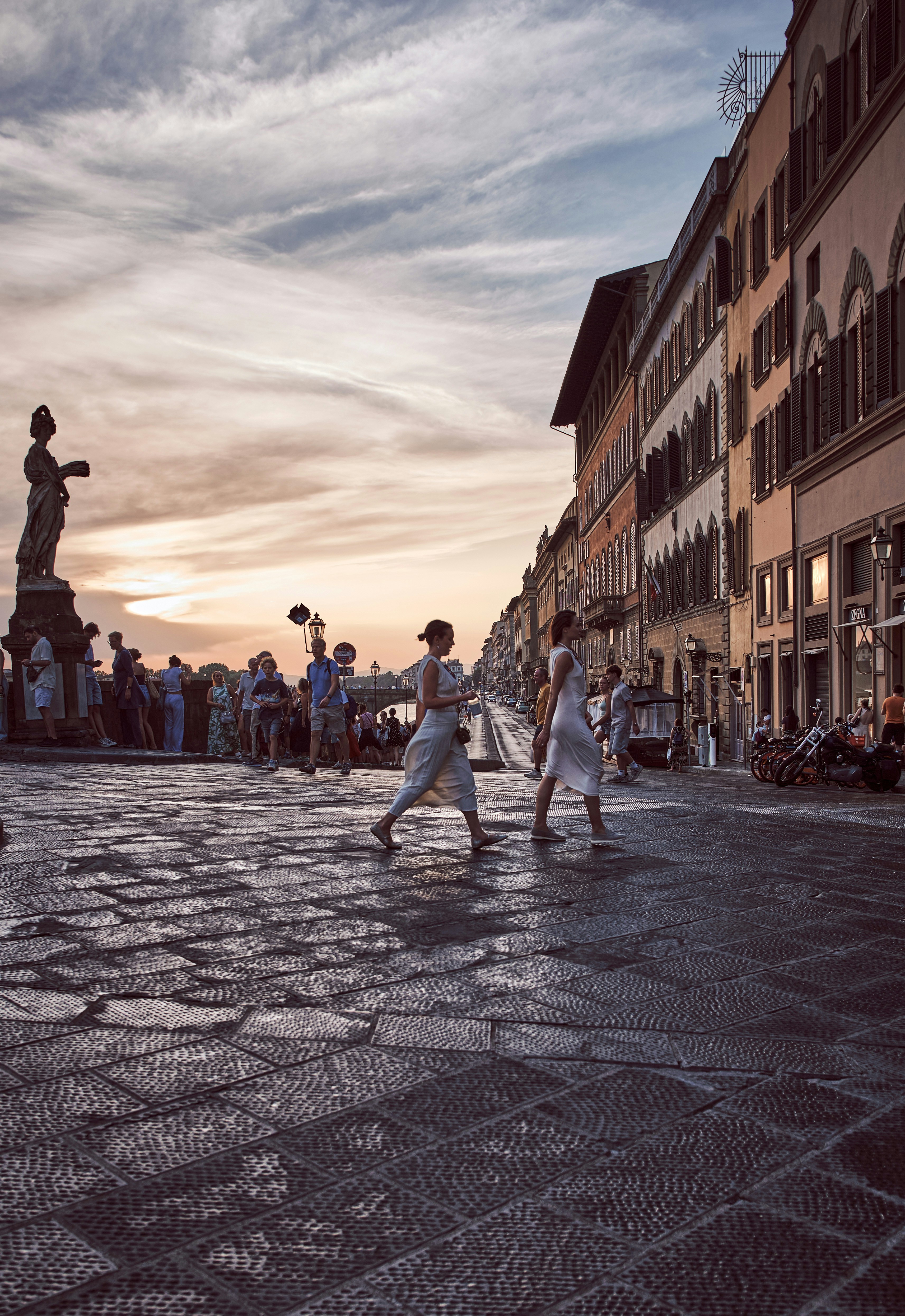 Sunset Crossing: White-dressed pedestrians navigate a historic Italian street