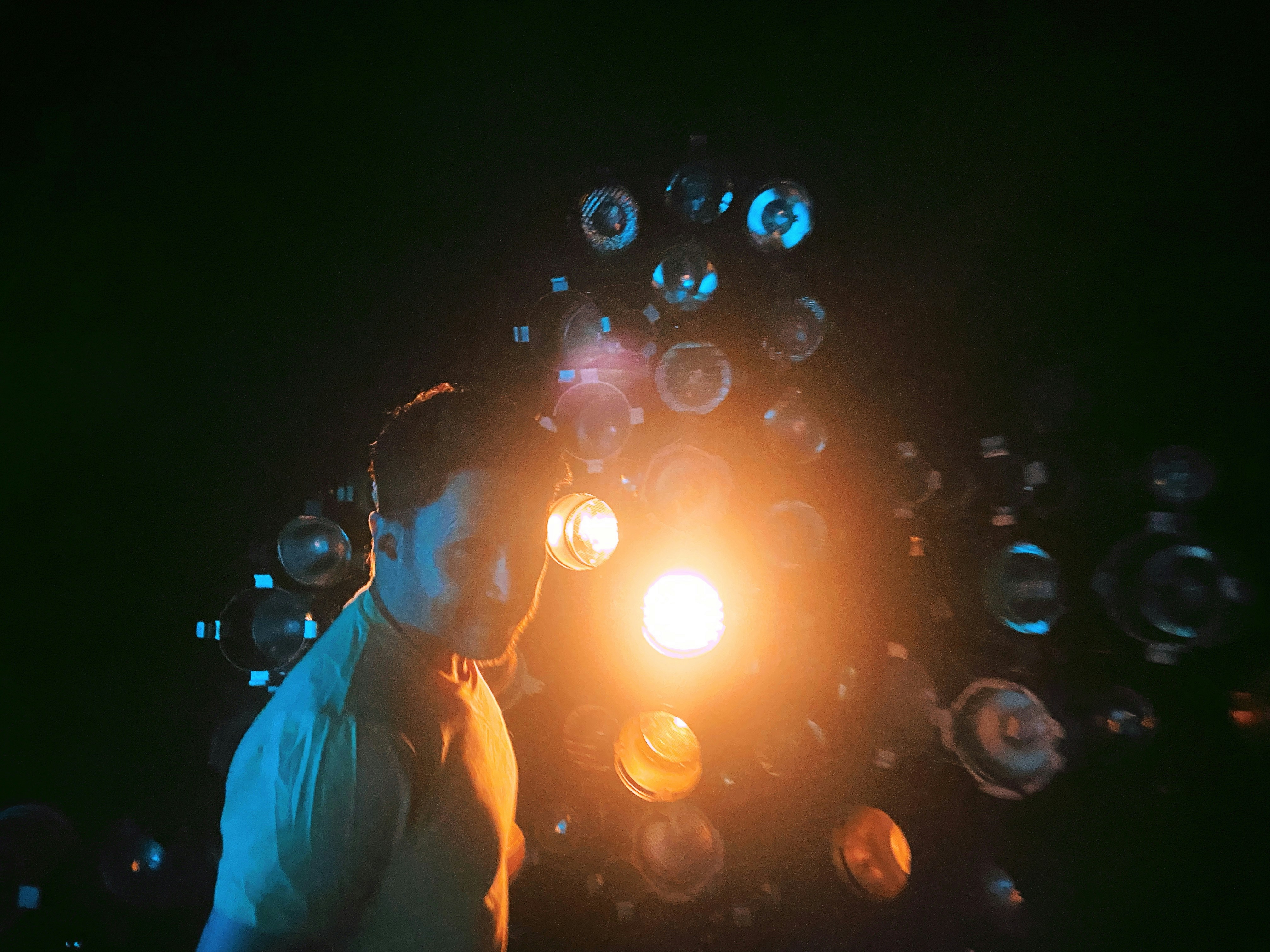 Backlit Portrait of a Man Among Floating Orbs and Light Orbs