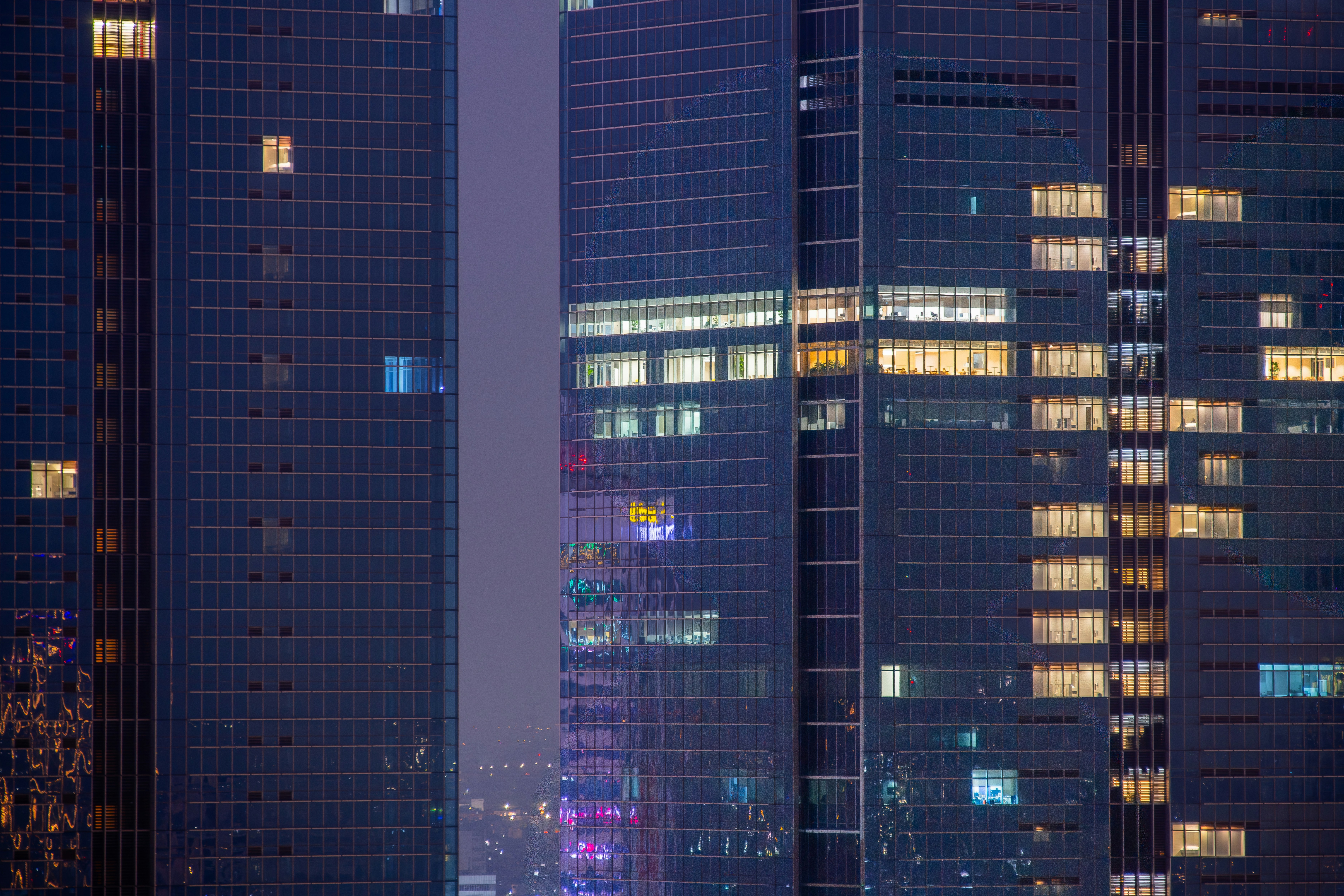 Urban Veil: Nighttime Glass and Neon Between Skyscrapers