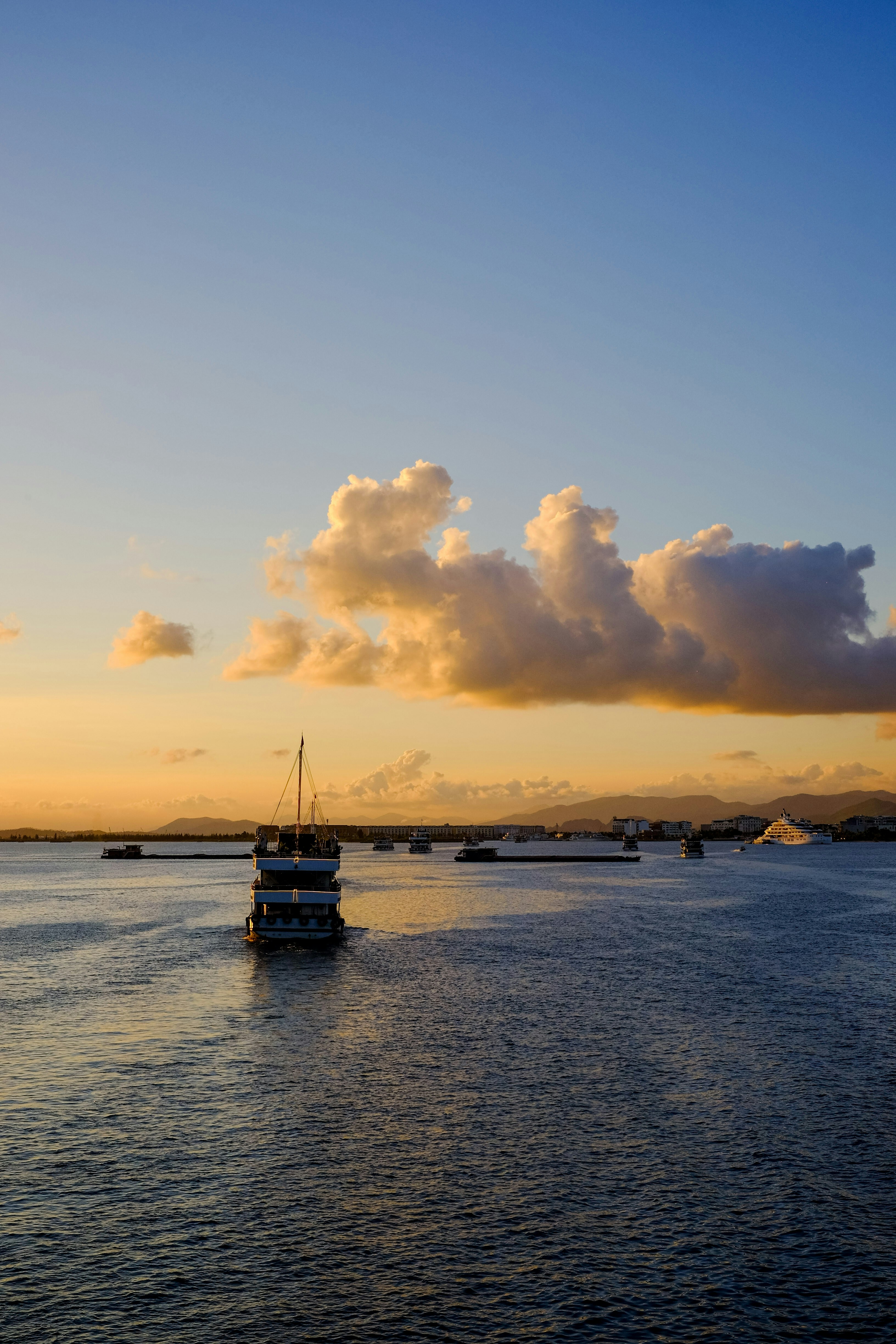 Sunlit Boats at Dusk over a Quiet Seascape
