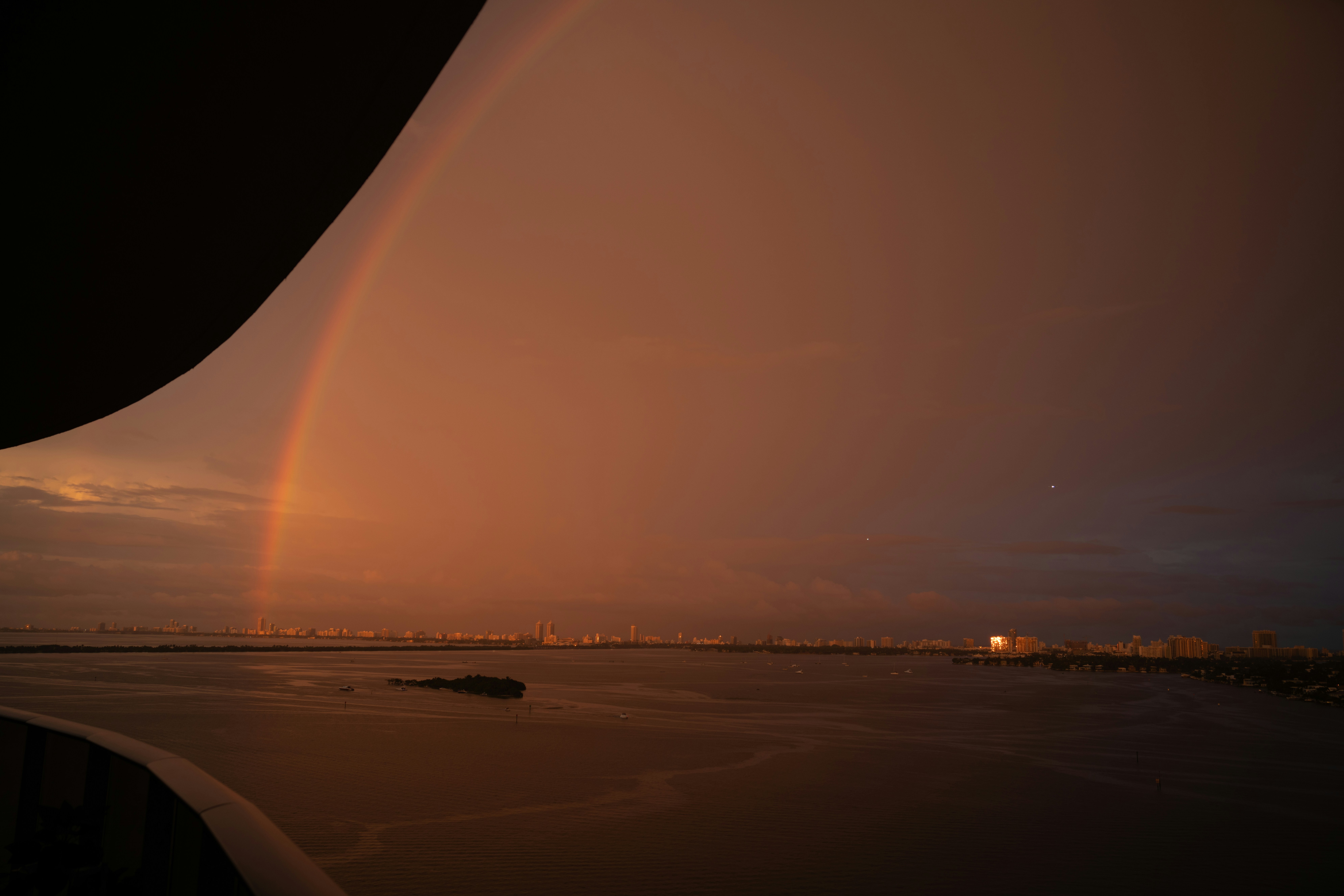 Arc of Light: Rainbow over a Quiet Seaside Sunset