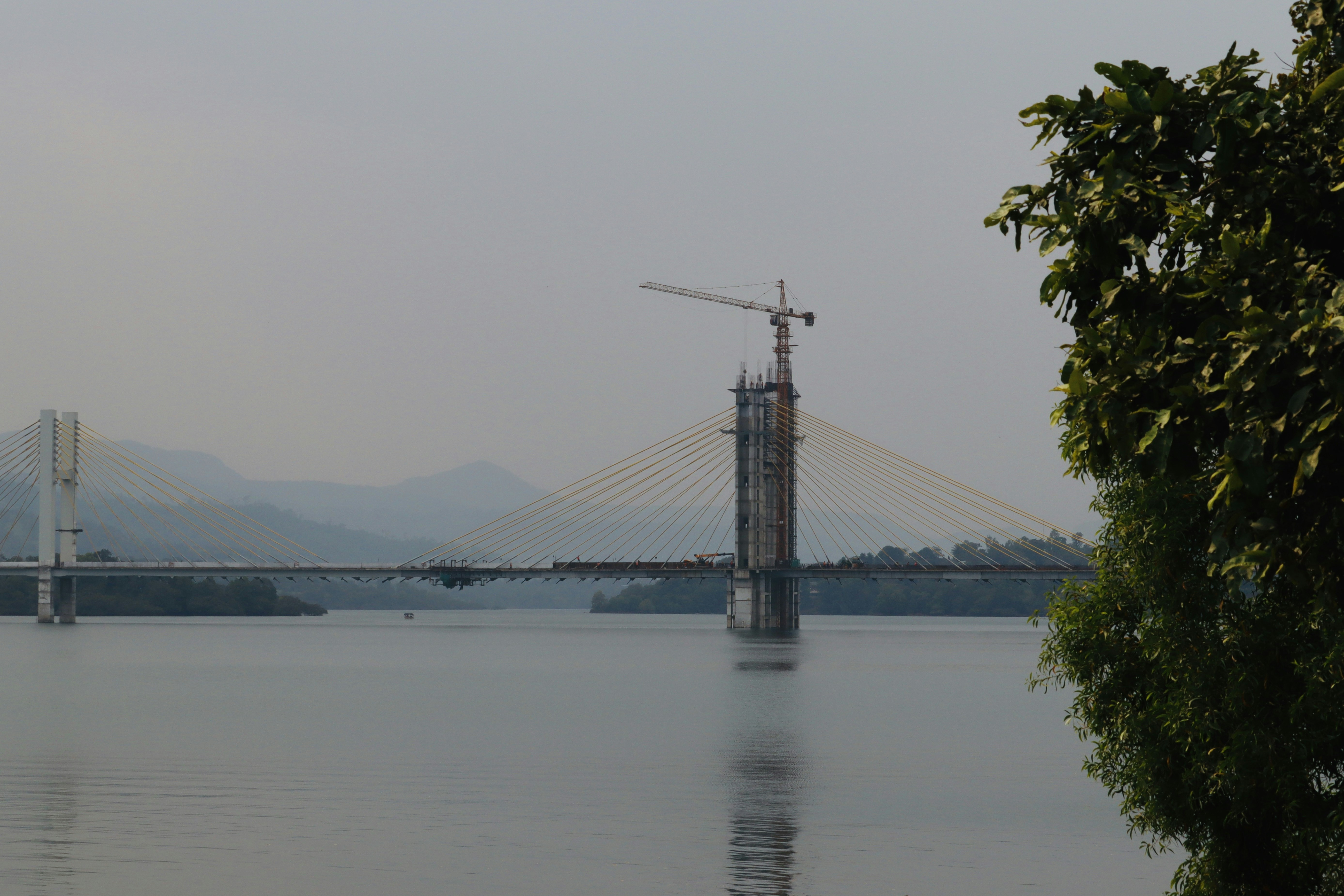 Bridge Under Construction: Crane Rising Over the Quiet River