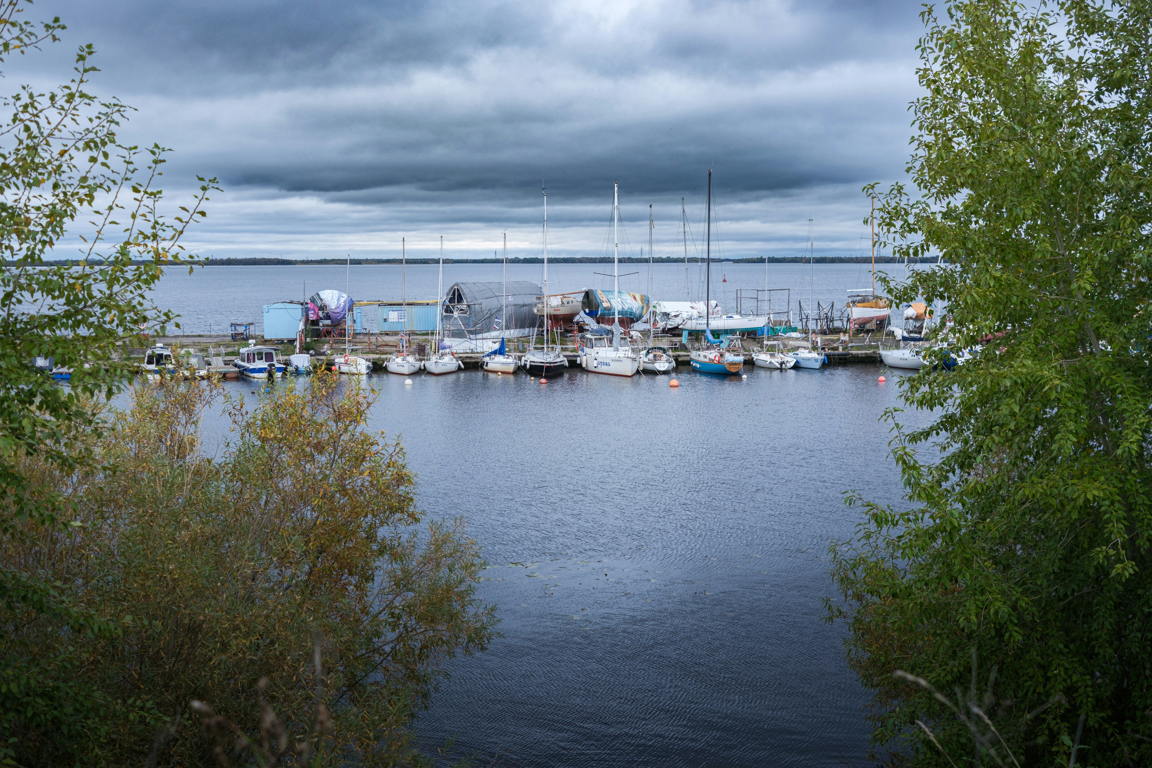 Sailboats at Rest: Quiet Marina Framed by Green Arches