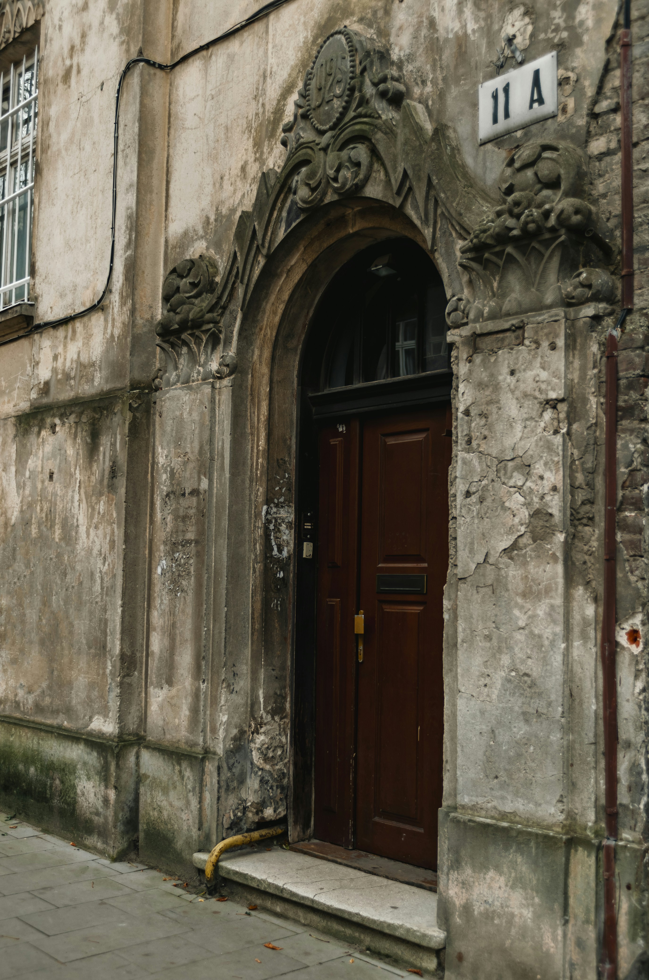 Weathered Archways: A Lintel Door Beneath Timeworn Ornament