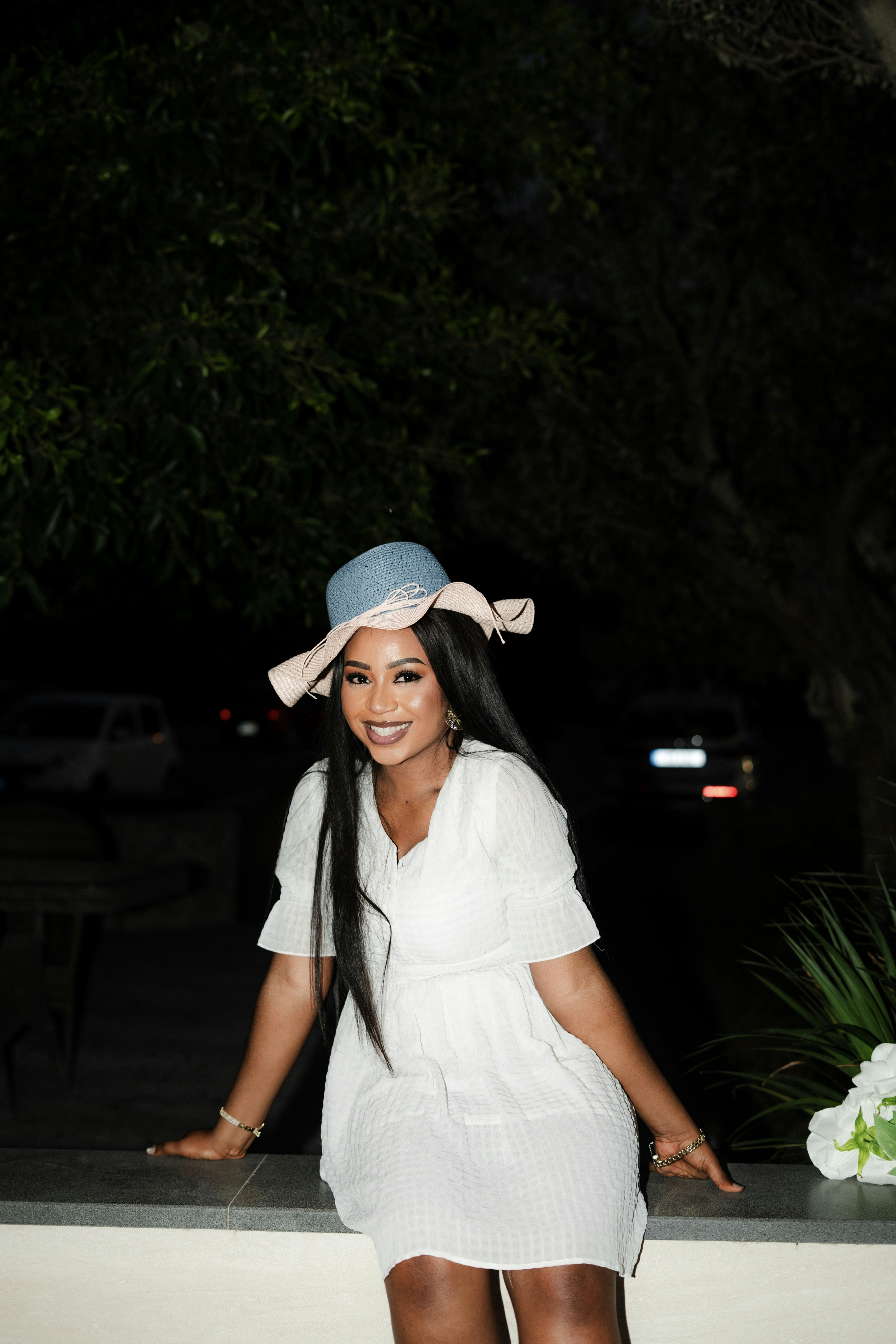 White-dressed soirée on a moonlit ledge with a velvet hat