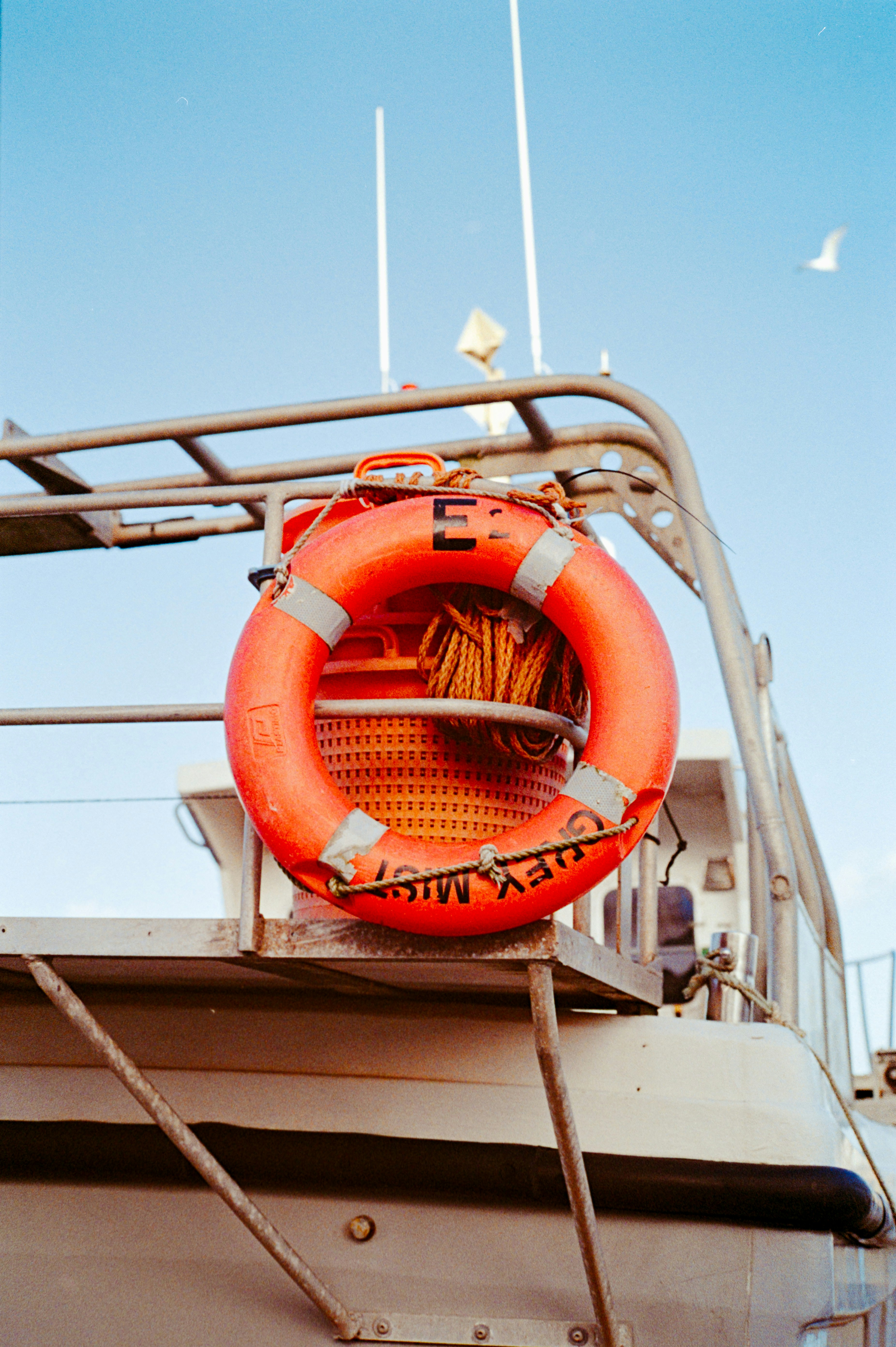 Orange Lifebuoy on a Vessel: Bright Safety at the Rail