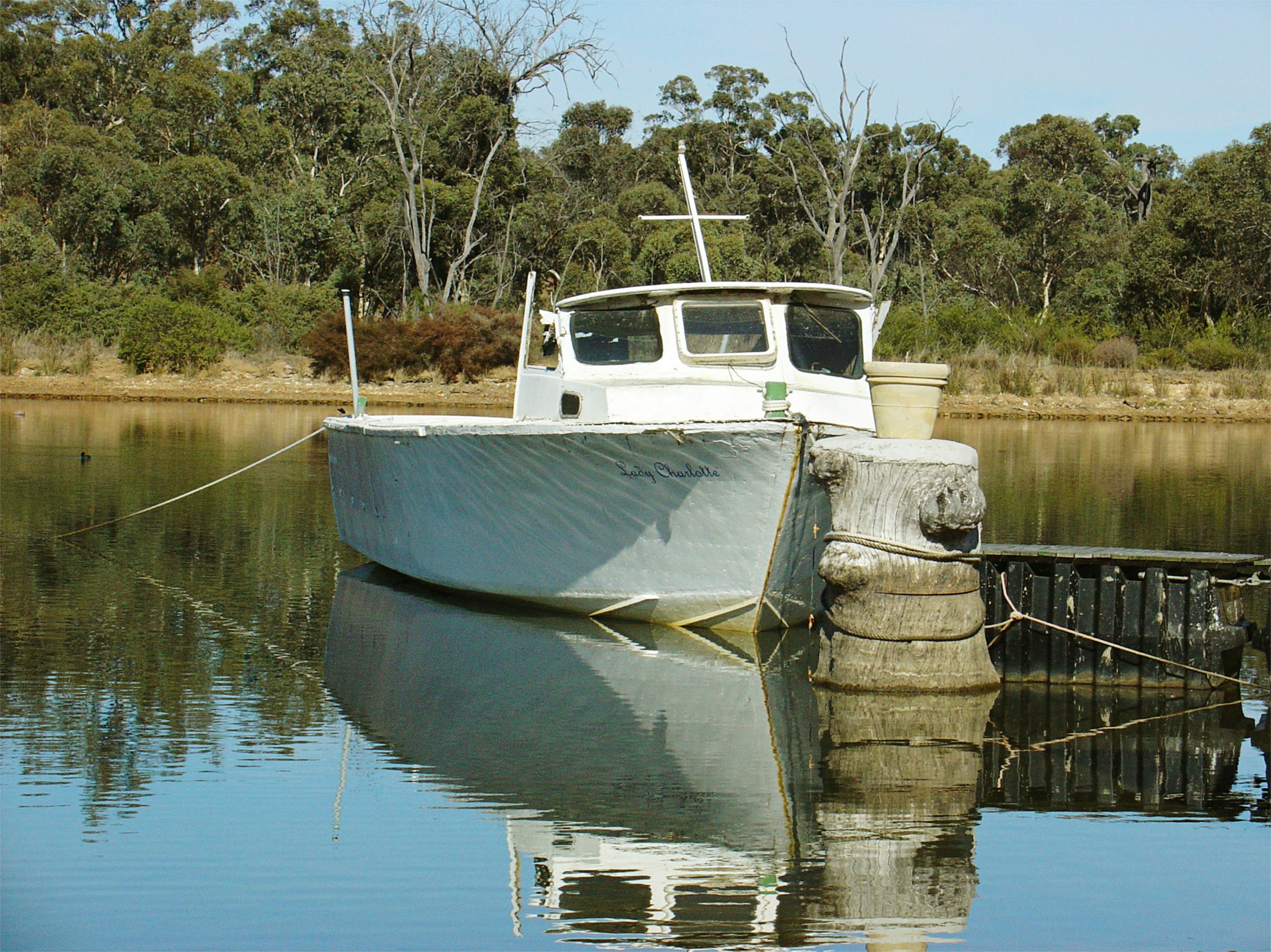 Tail of a Quiet Harbor: The Boat and Its Mirror