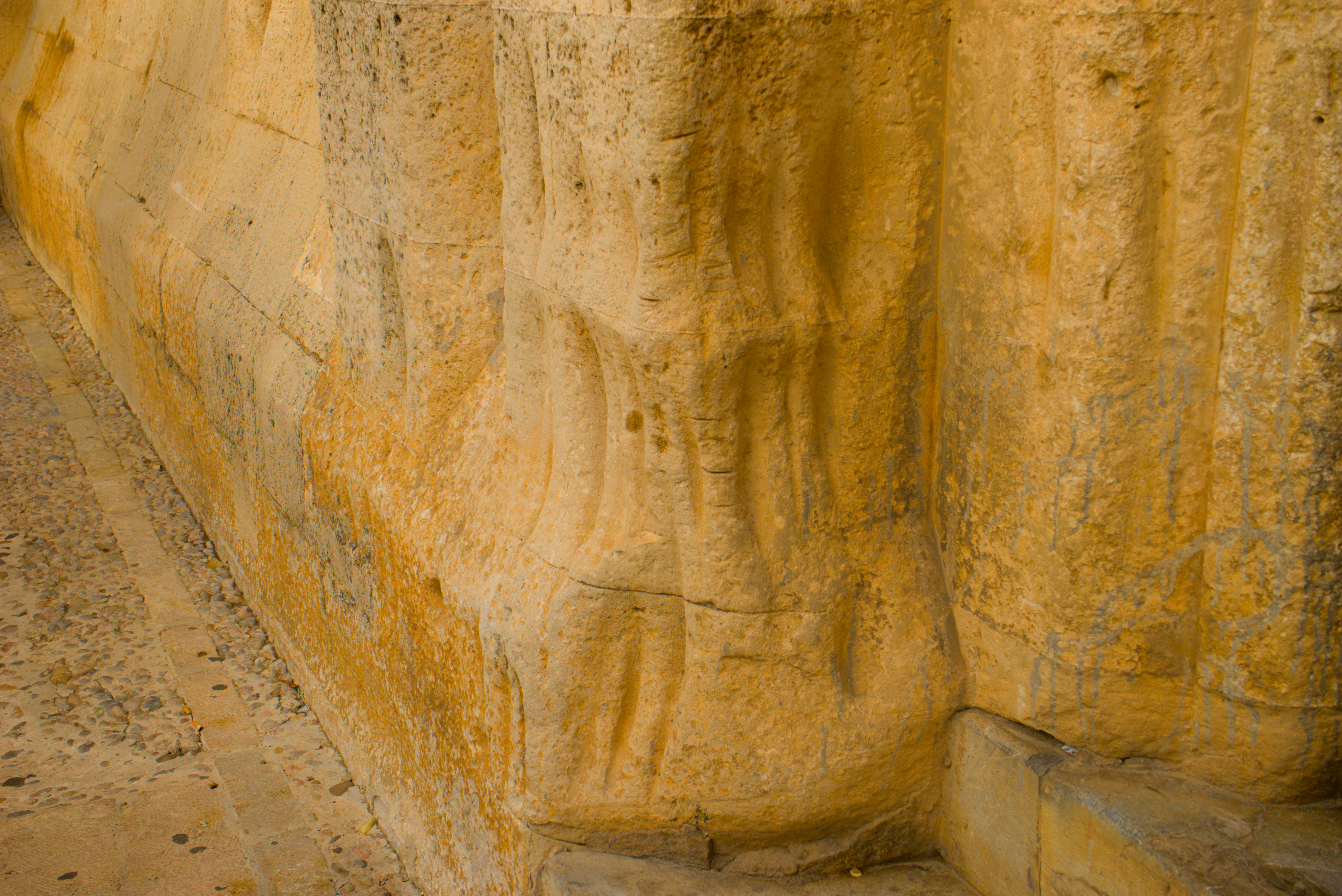Carved Stone Corridor: Weathered Columns and Grottoed Reliefs