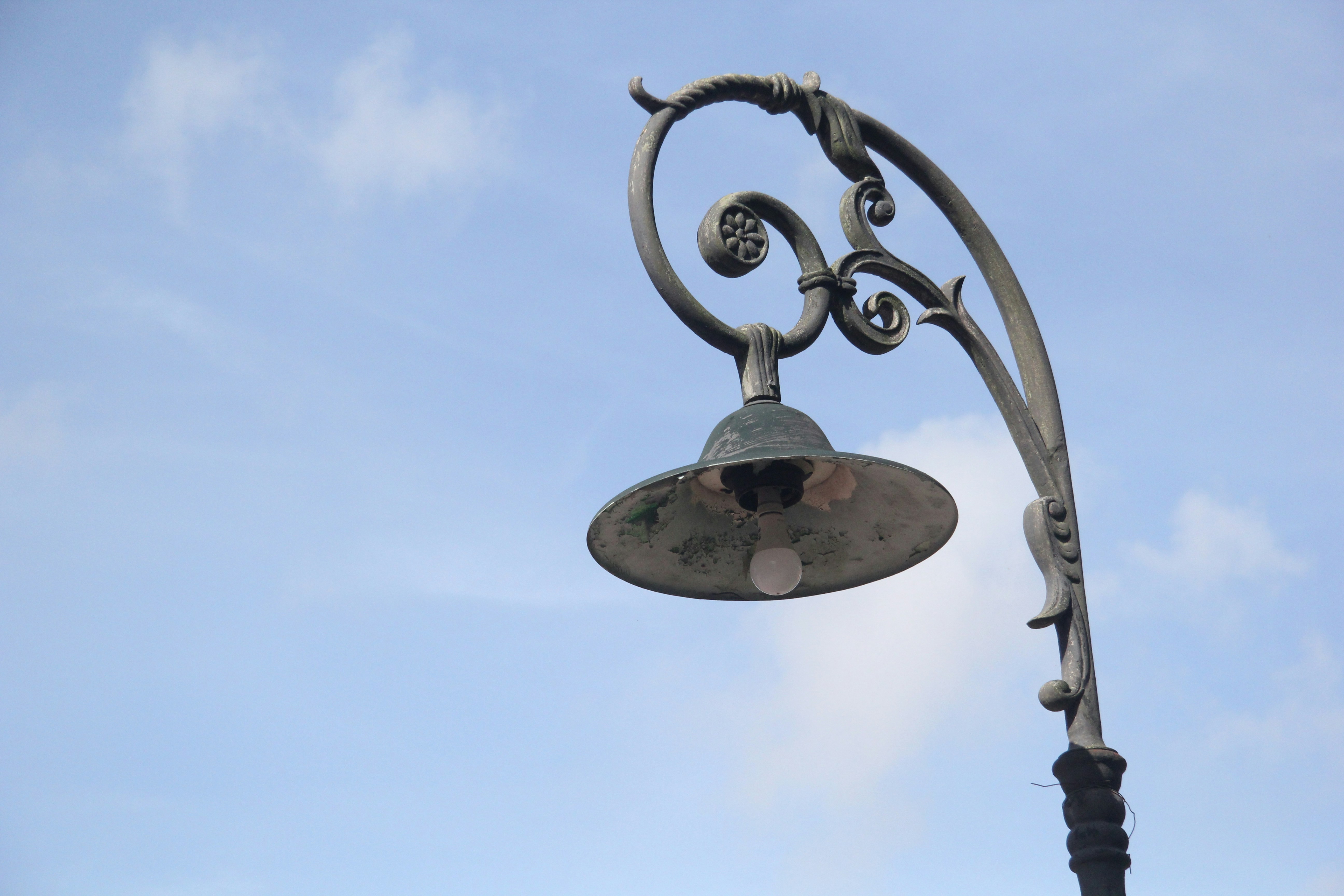Lokian Arc: A Weathered Lamp Reaches Toward Open Sky