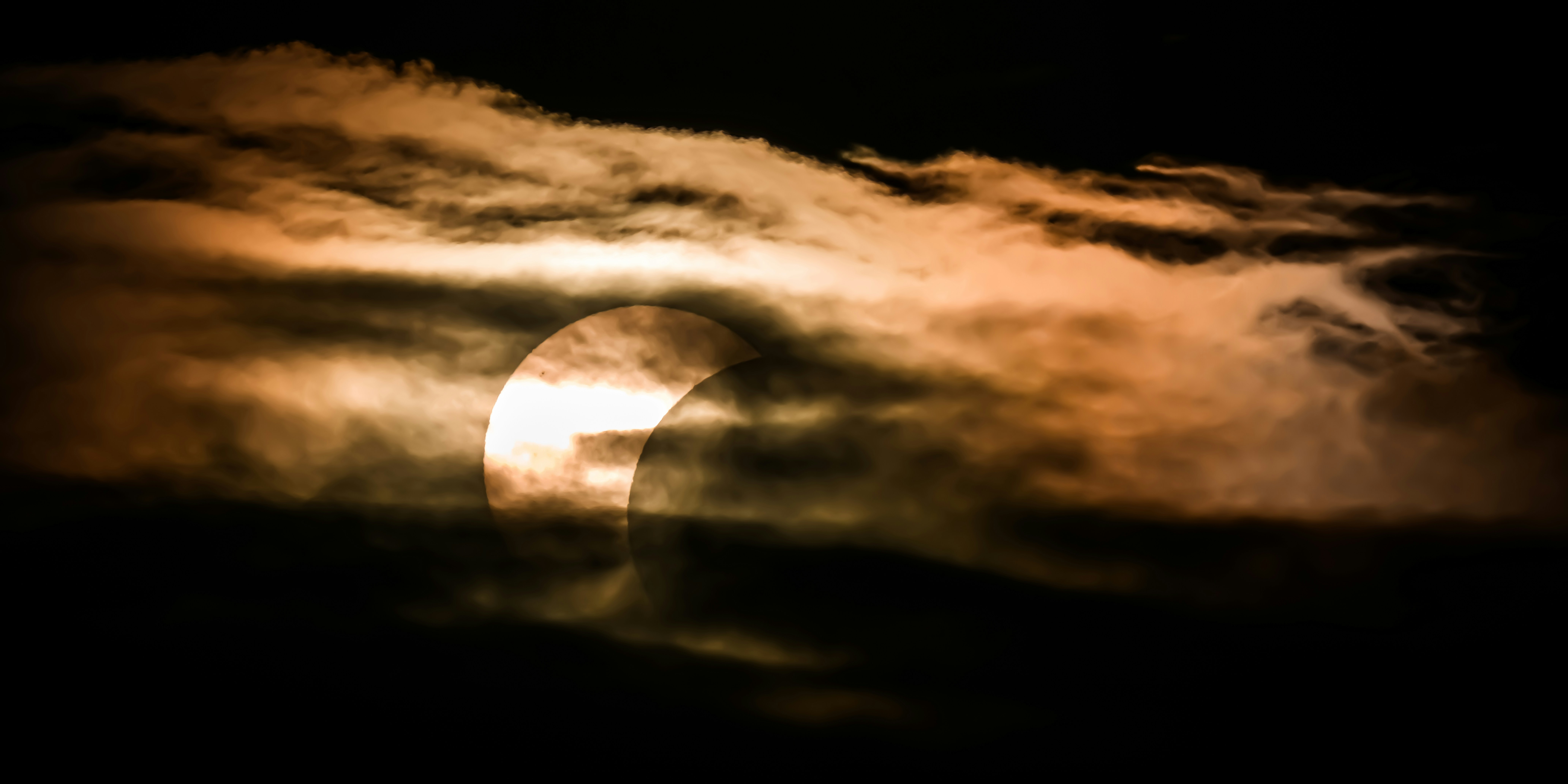 Solar Fringe: A Partial Eclipse Emerges Through Cloud Veil