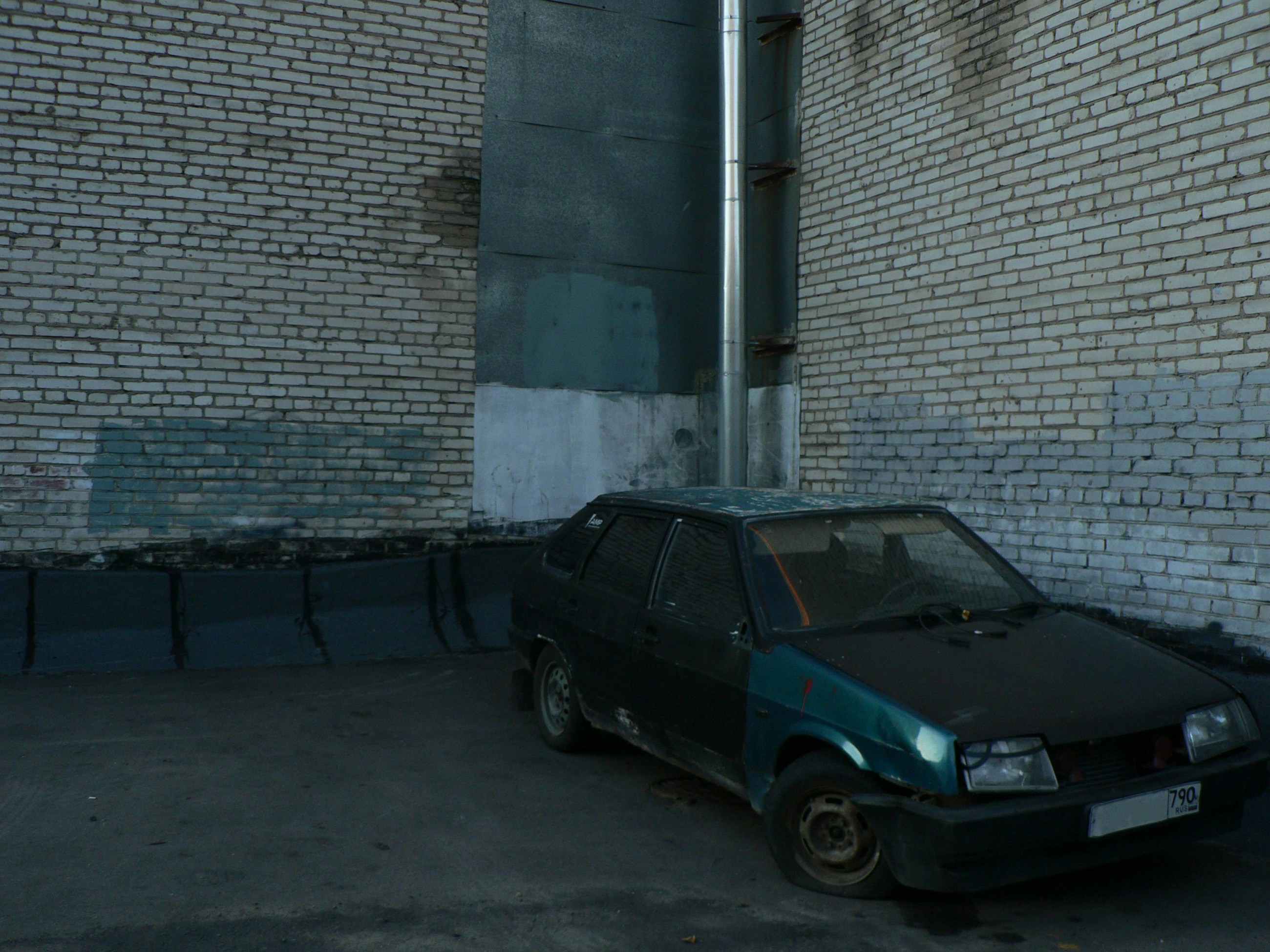 Abandoned Green Sedan under Industrial Rooflights