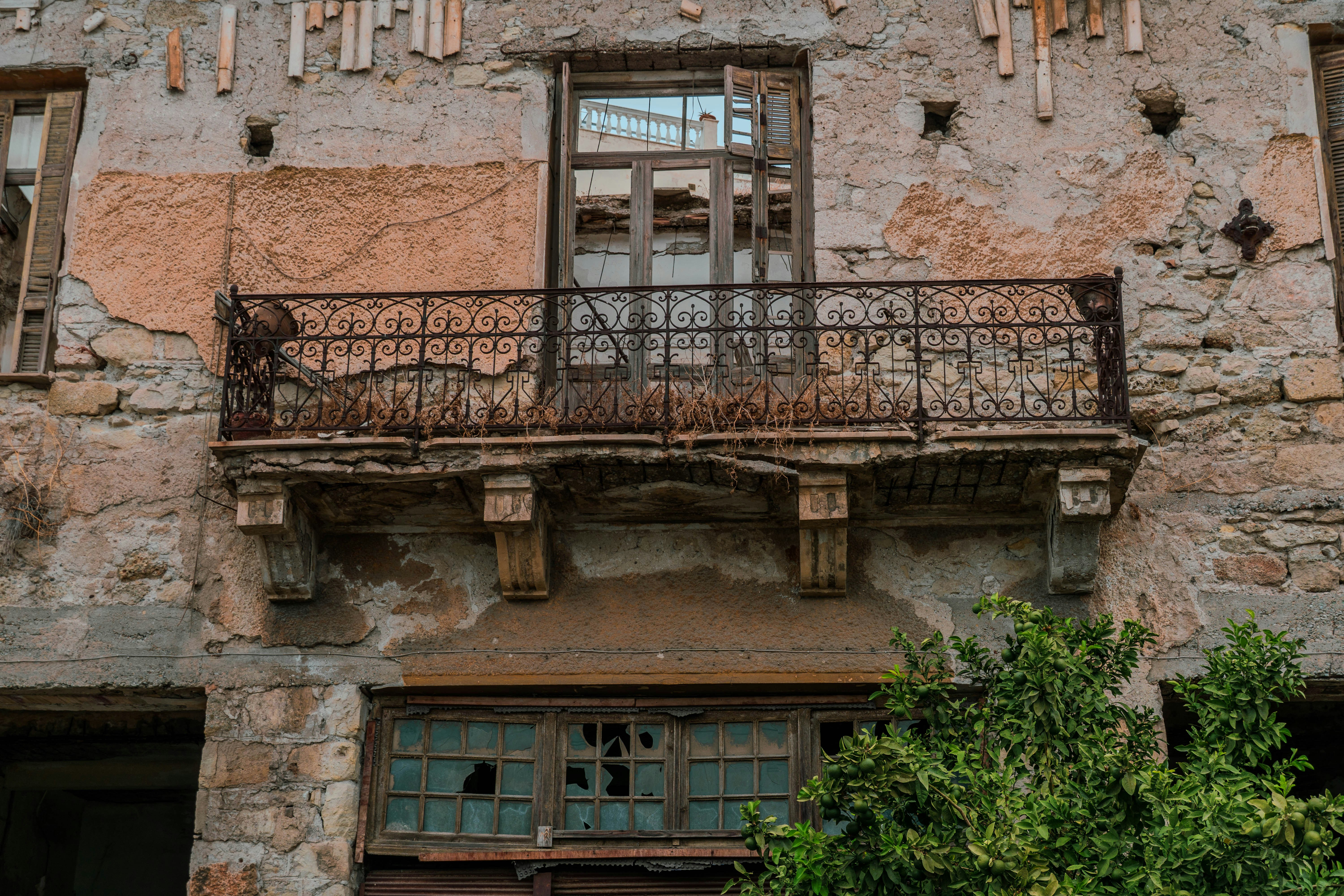 Crumbled Balcony Overgrowth on a Weathered Facade