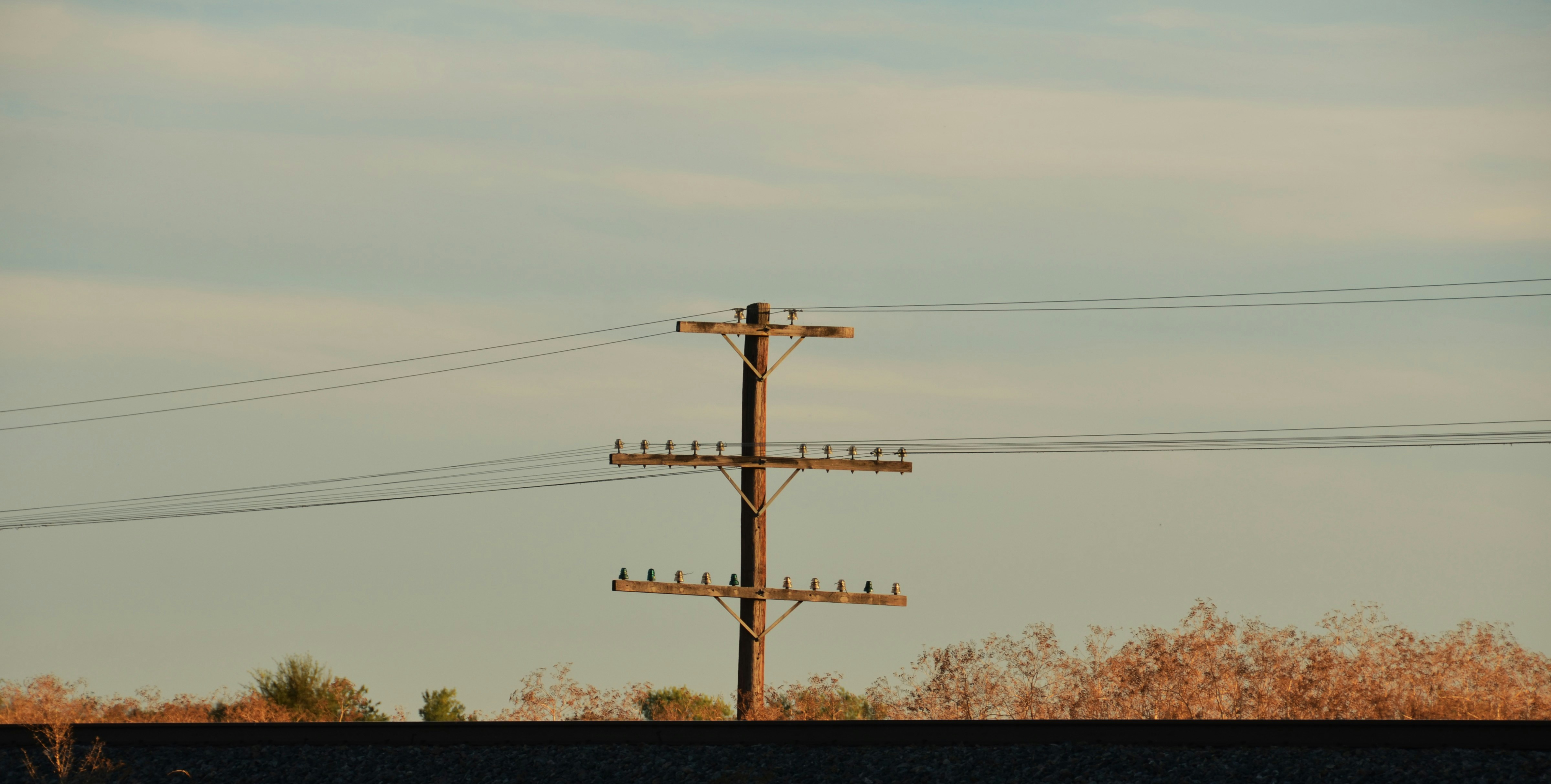 Silent Backbone: A lone utility pole quietly bisects the horizon