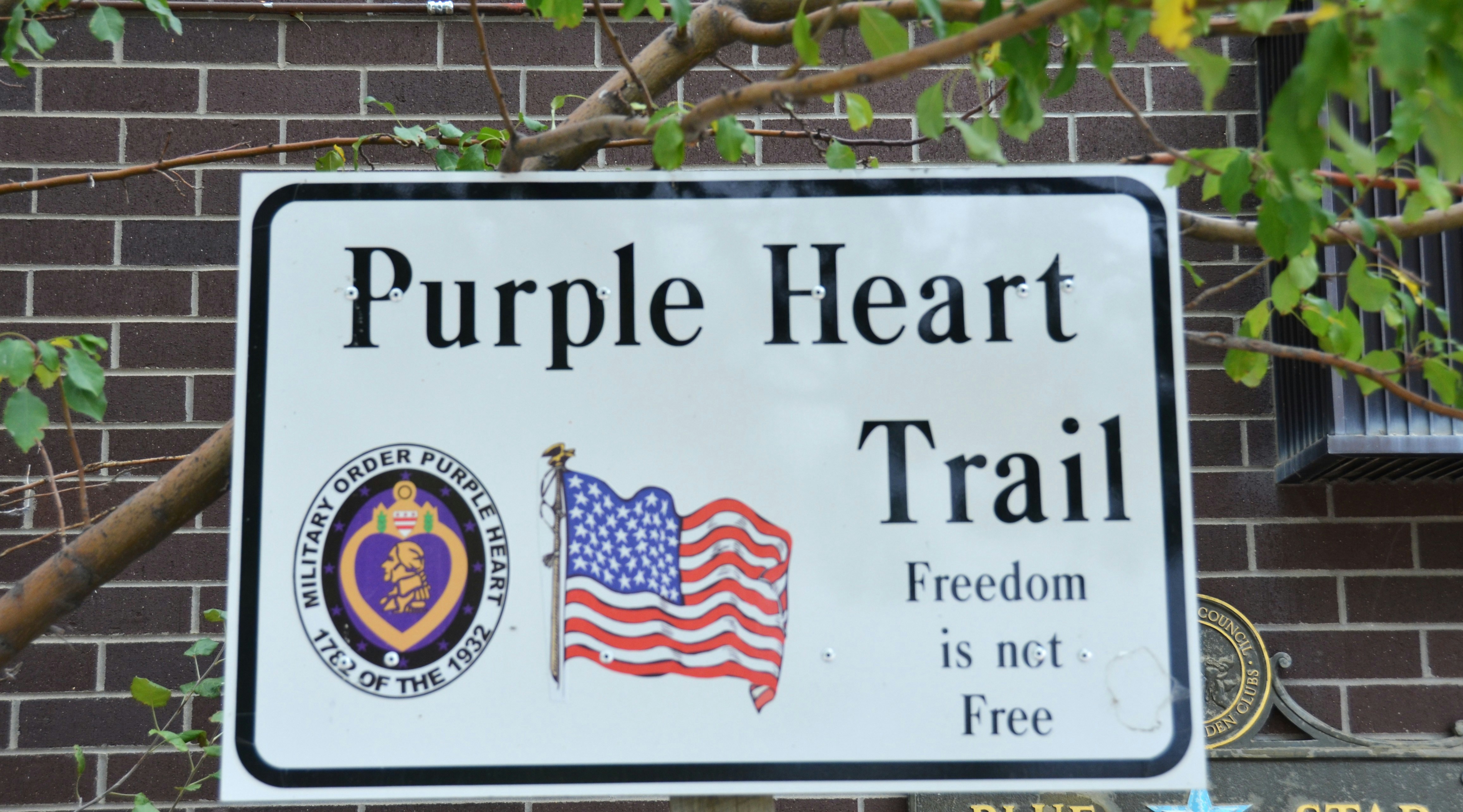 Purple Heart Trail Sign: Freedom Inscribed and Flags in the Brick backdrop
