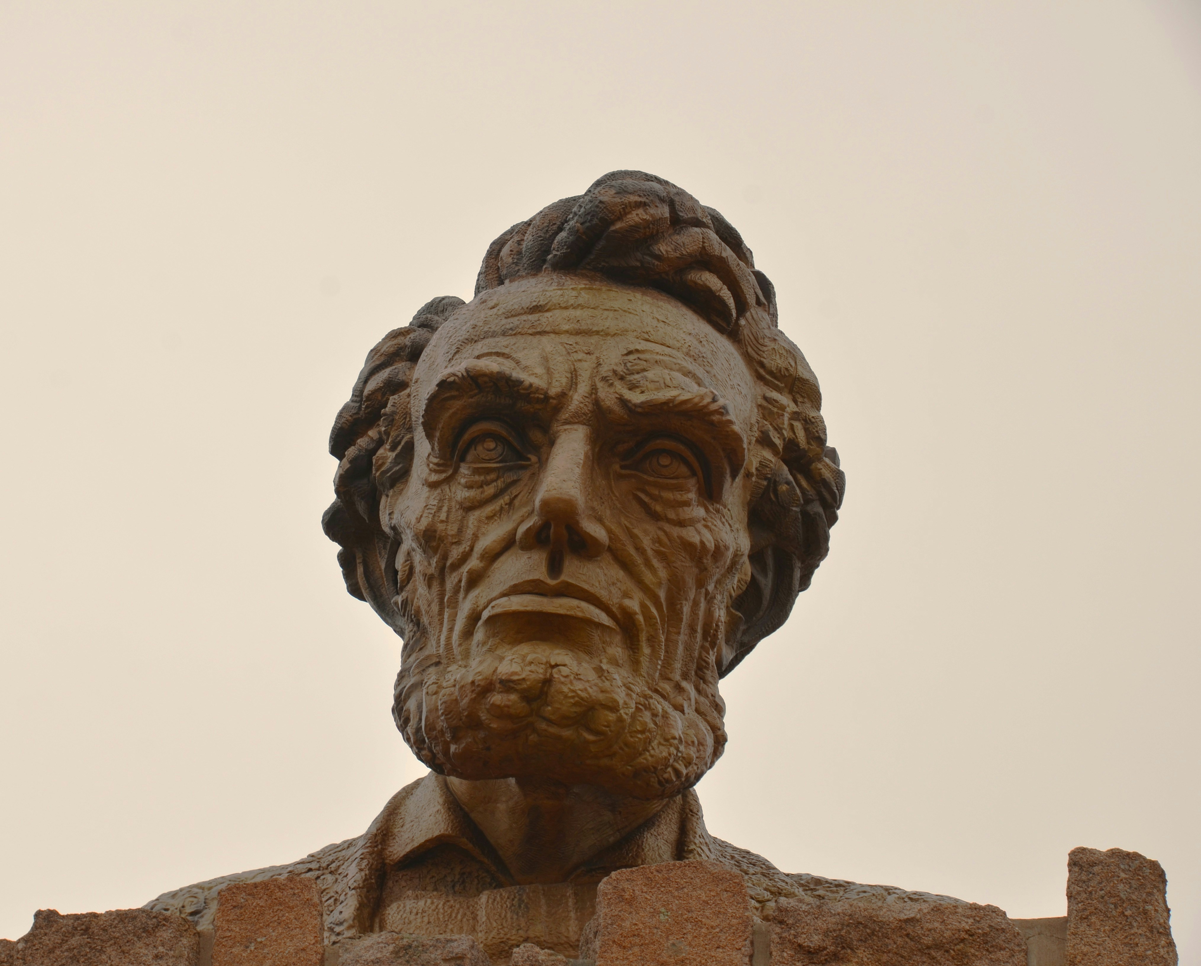 Stone Portrait of a Weathered Philosopher Reaching Toward the Sky