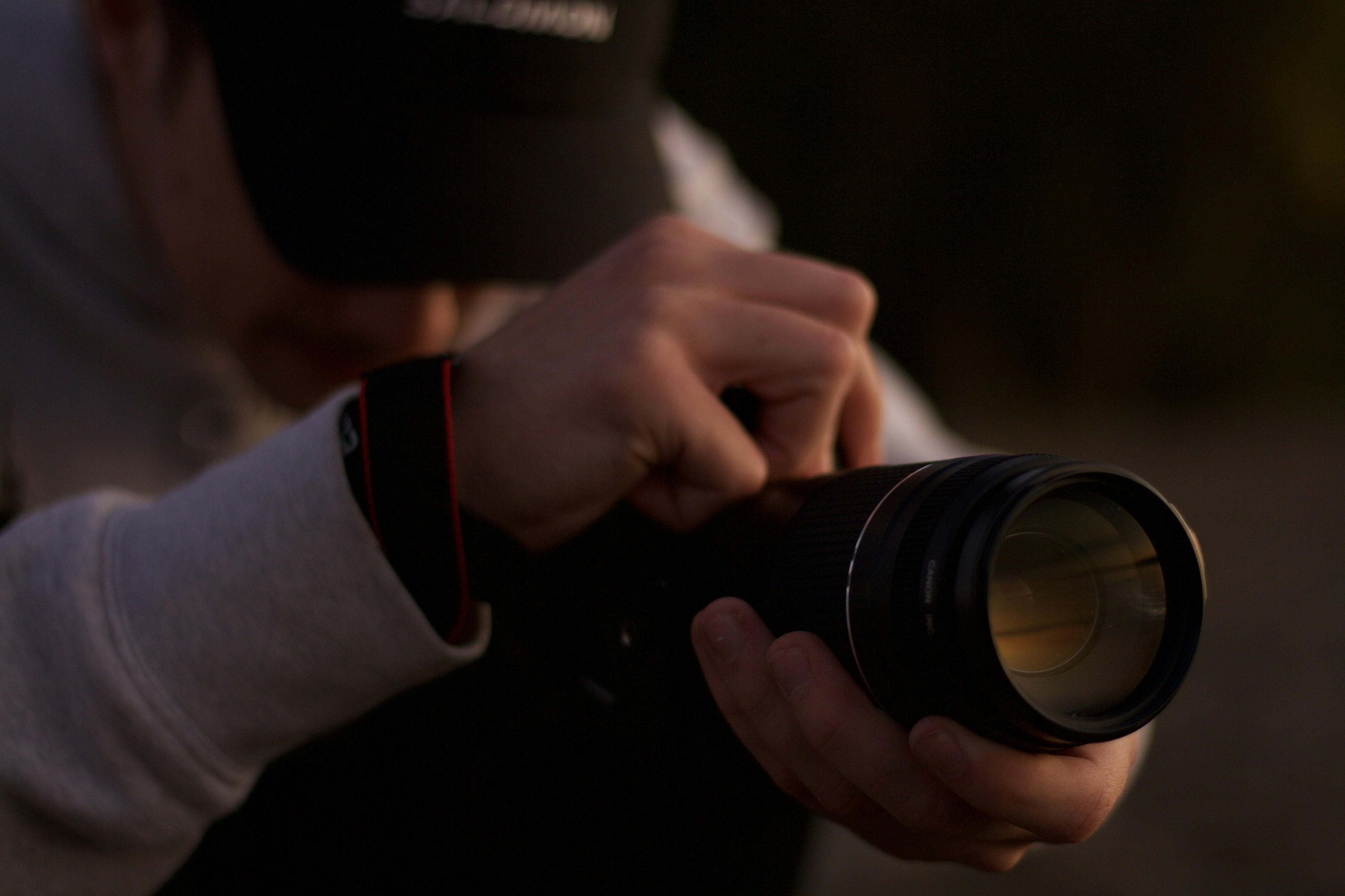 Shadowed Focus: A Photographer's Hold on the Lens