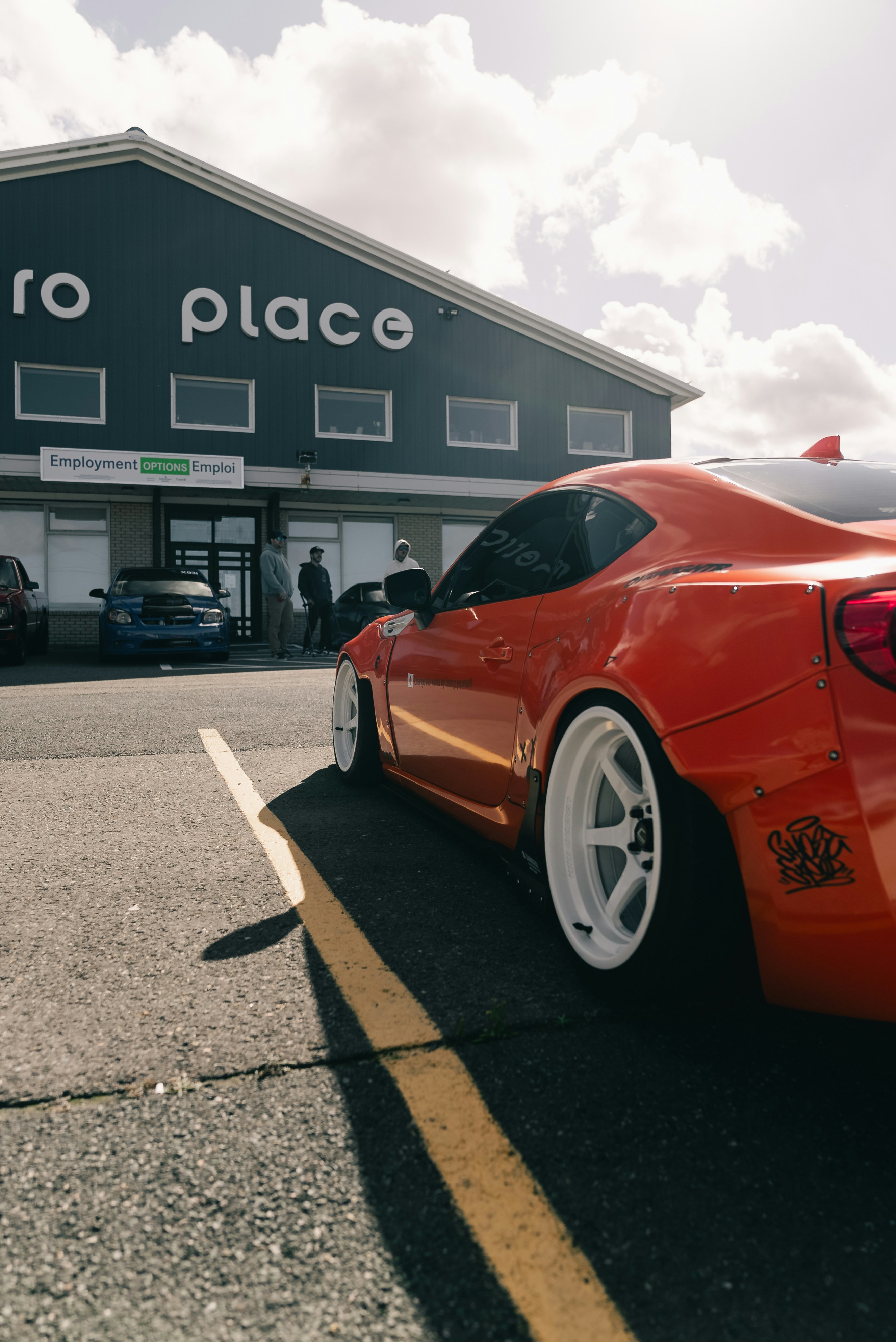 Orange Stance: A Low-Angle Glimpse of Speed by the Warehouse