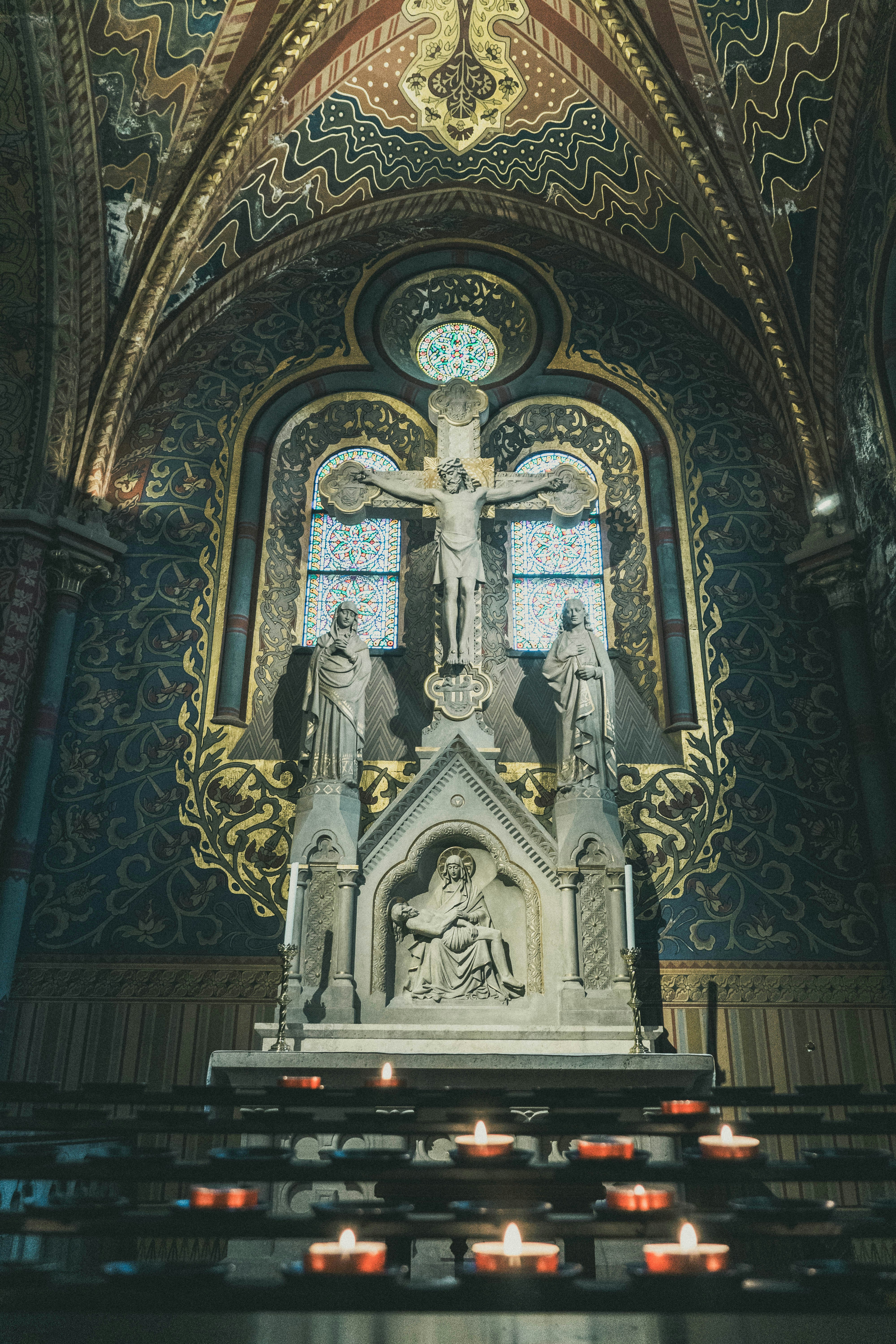 Cruciform Shrine Amid Ornate Murals and Flickering Candles