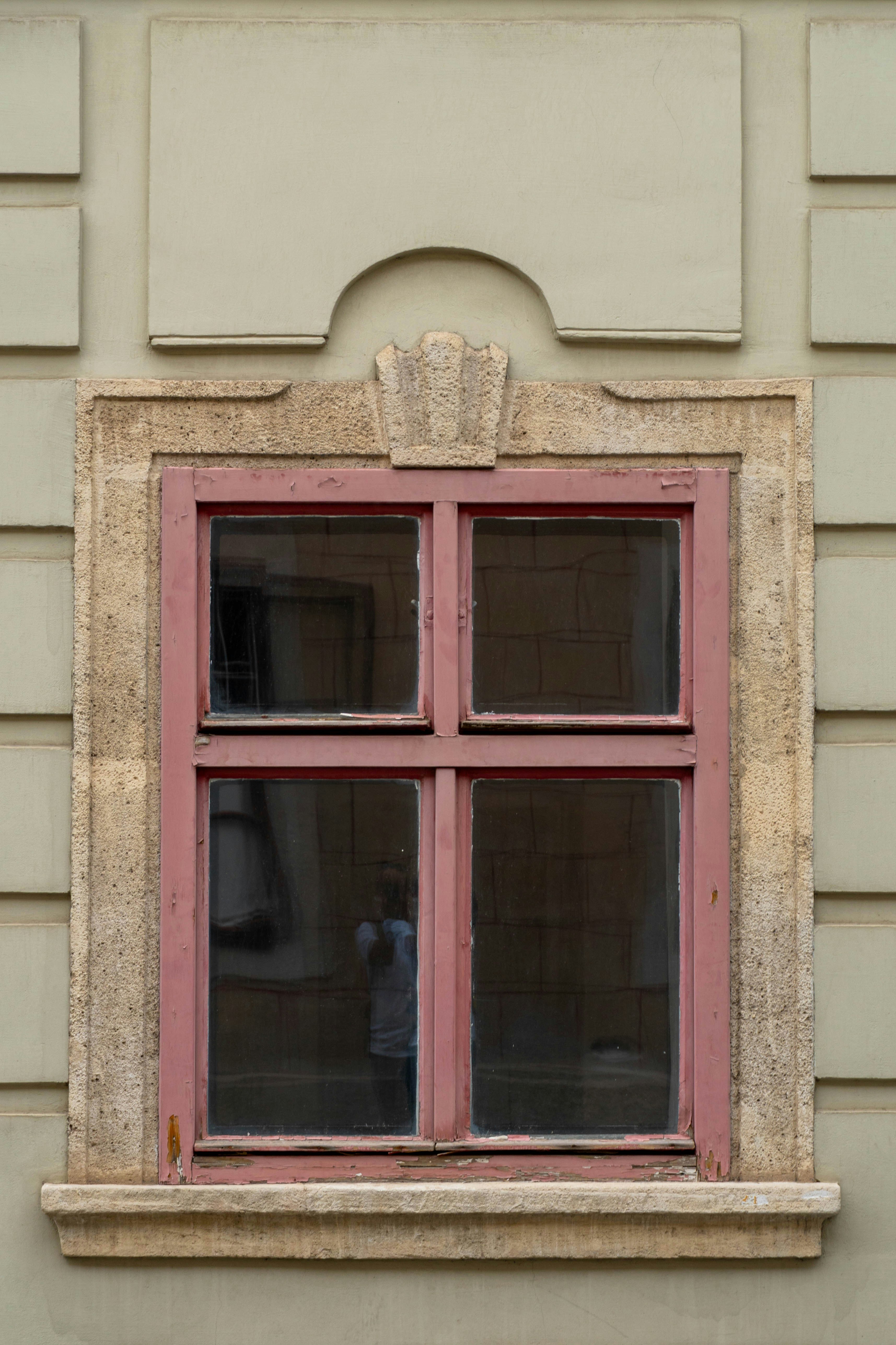Rust-red Window in Beige Facade: A Quiet Architectural Portrait
