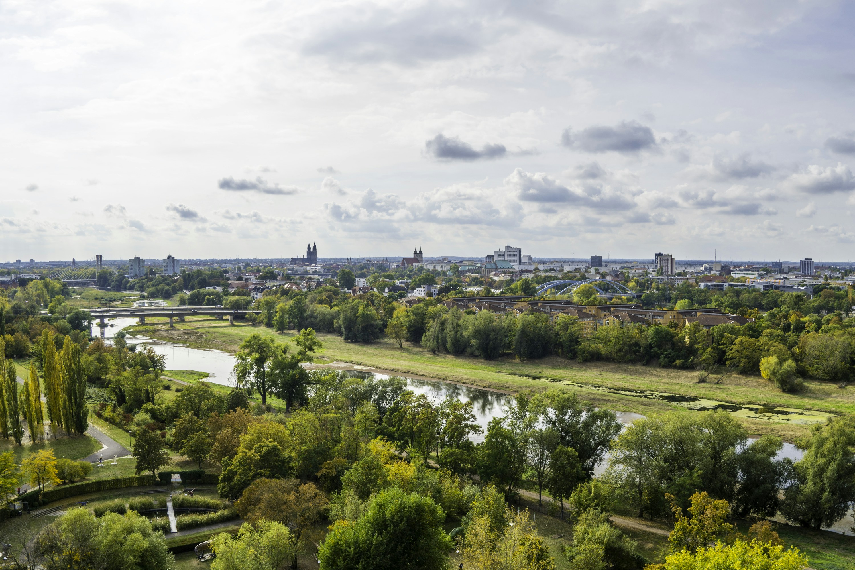Sunlit River Meanders Through a Tree-Green Cityscape