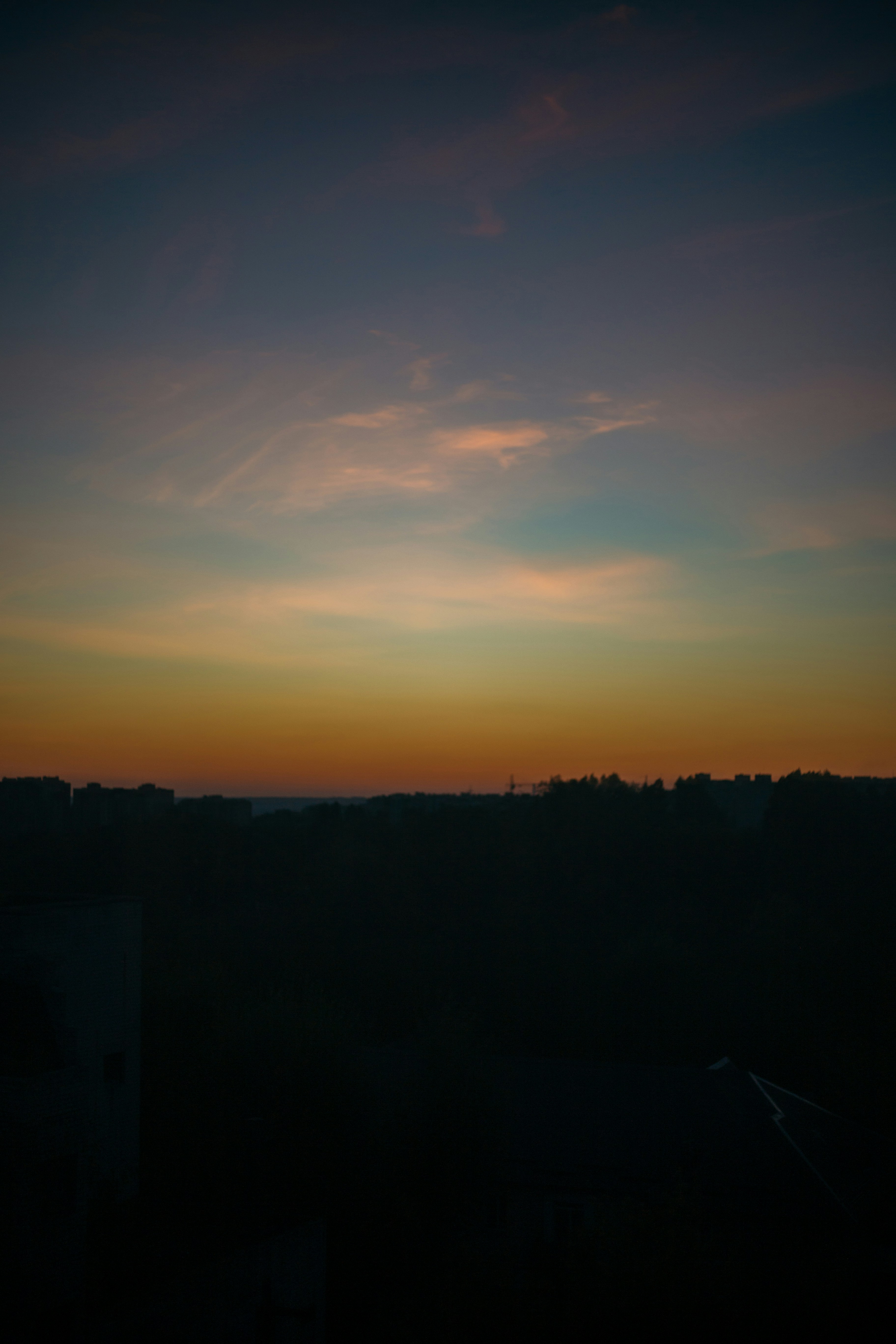 Dusk Horizon: Quiet City Silhouette Beneath Sunset Skies