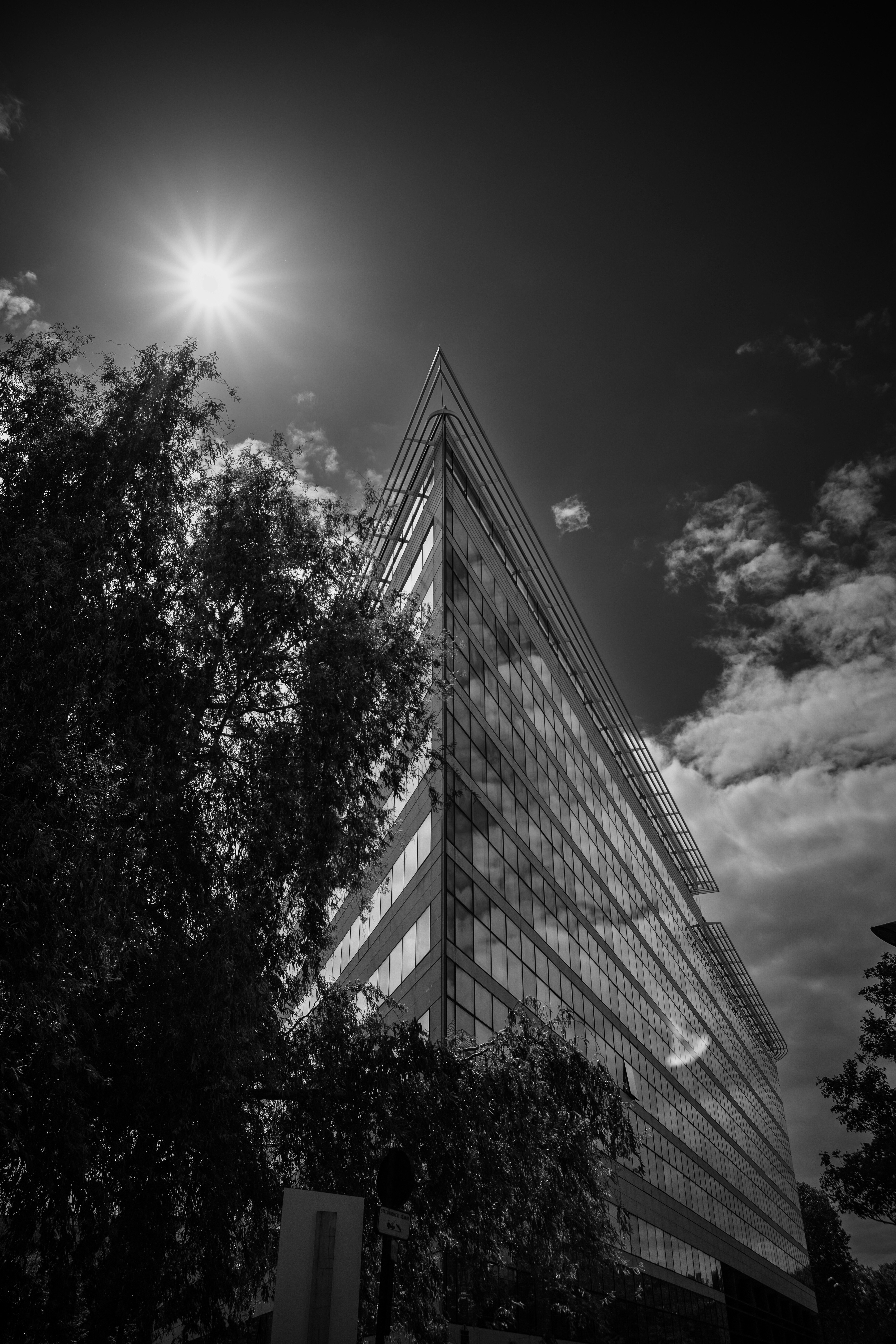 Glassy Prism: The Corner-Edge Tower Against a Brushed Sky