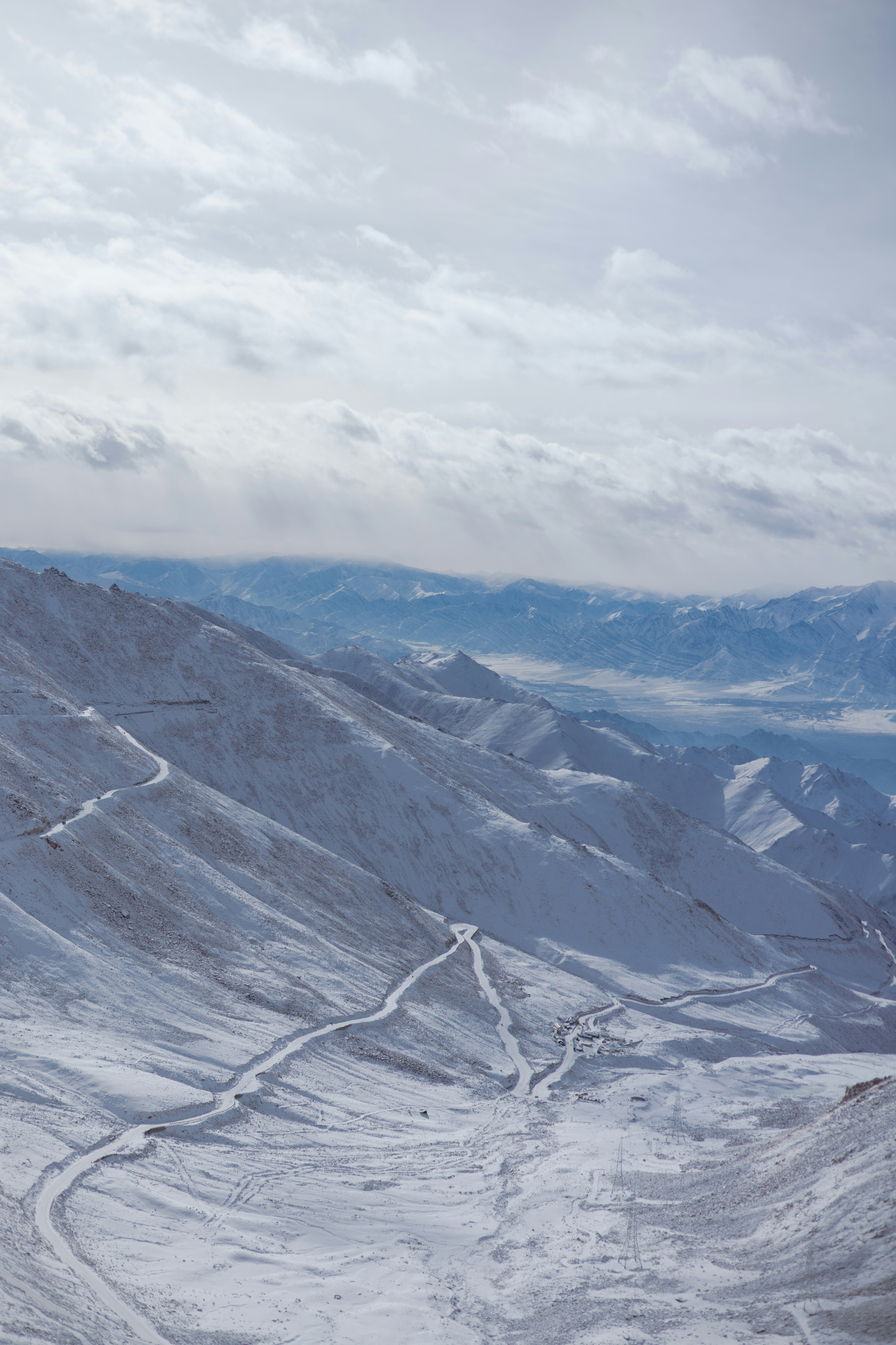 Snowbound Switchbacks: A Winding Alpine Road Snaking Through Quiet Peaks