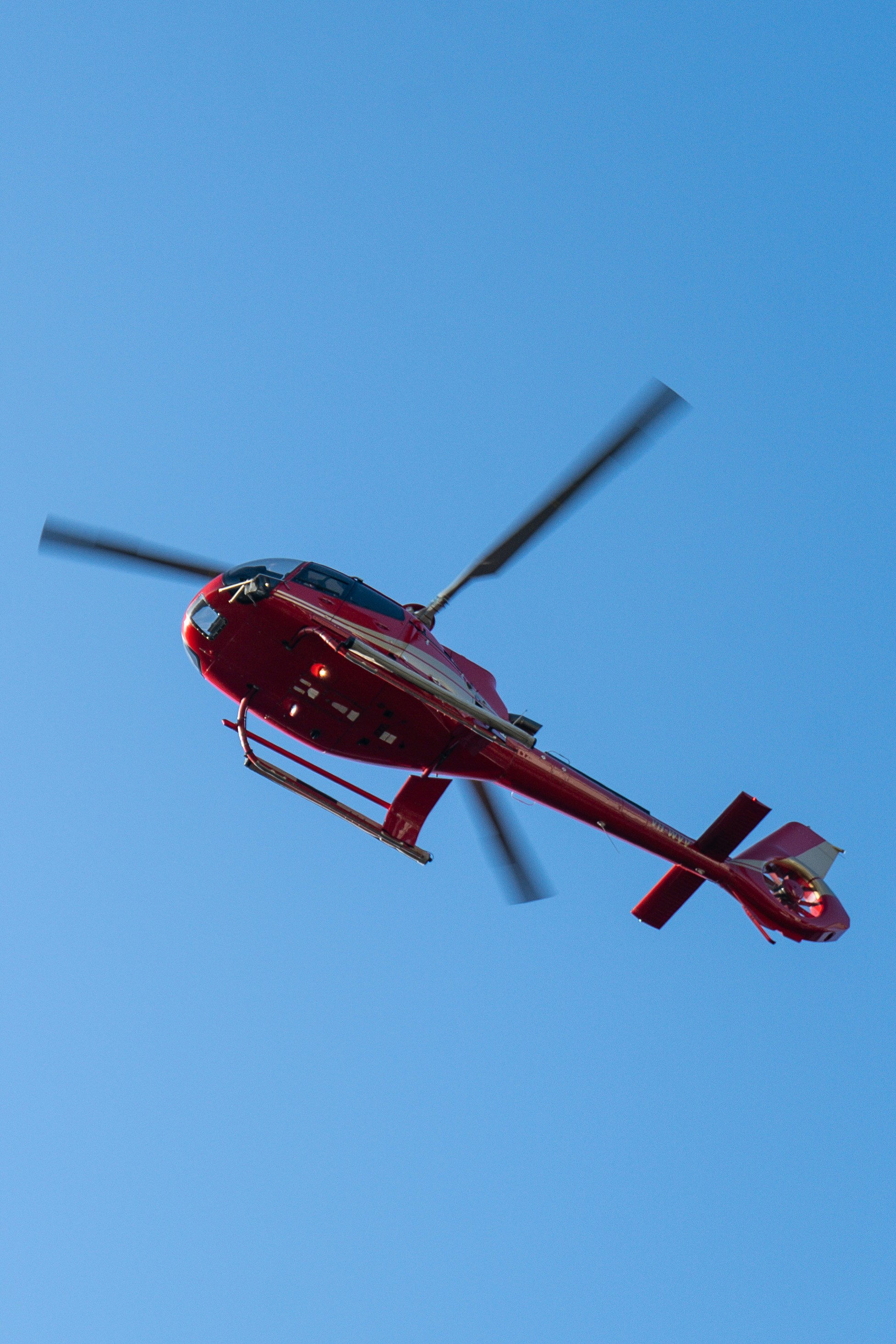 Crimson Rescue: A Red Helicopter Slices the Sky