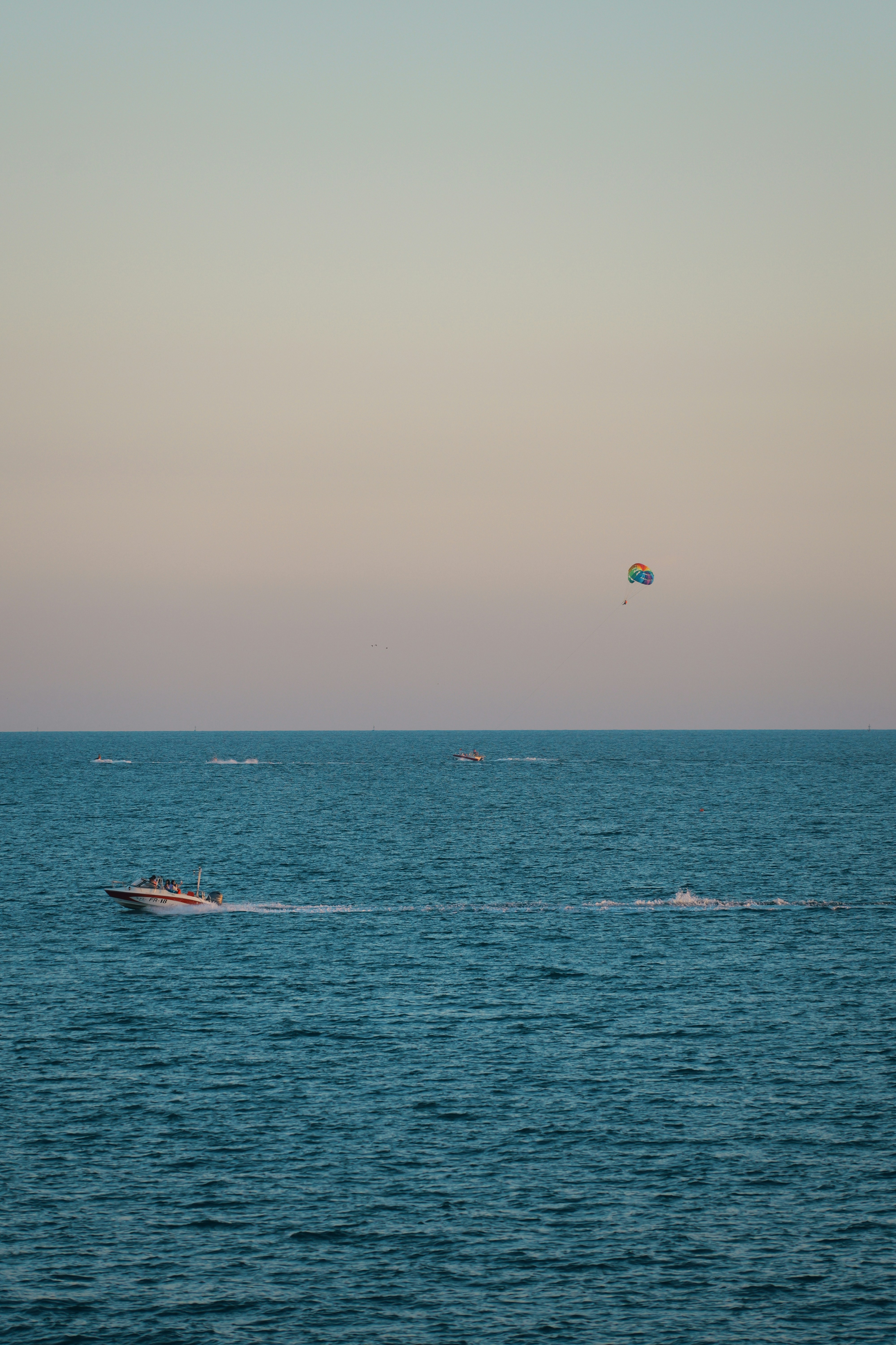 Sunset Sea: Paragliding Kite Hover over Quiet Blue