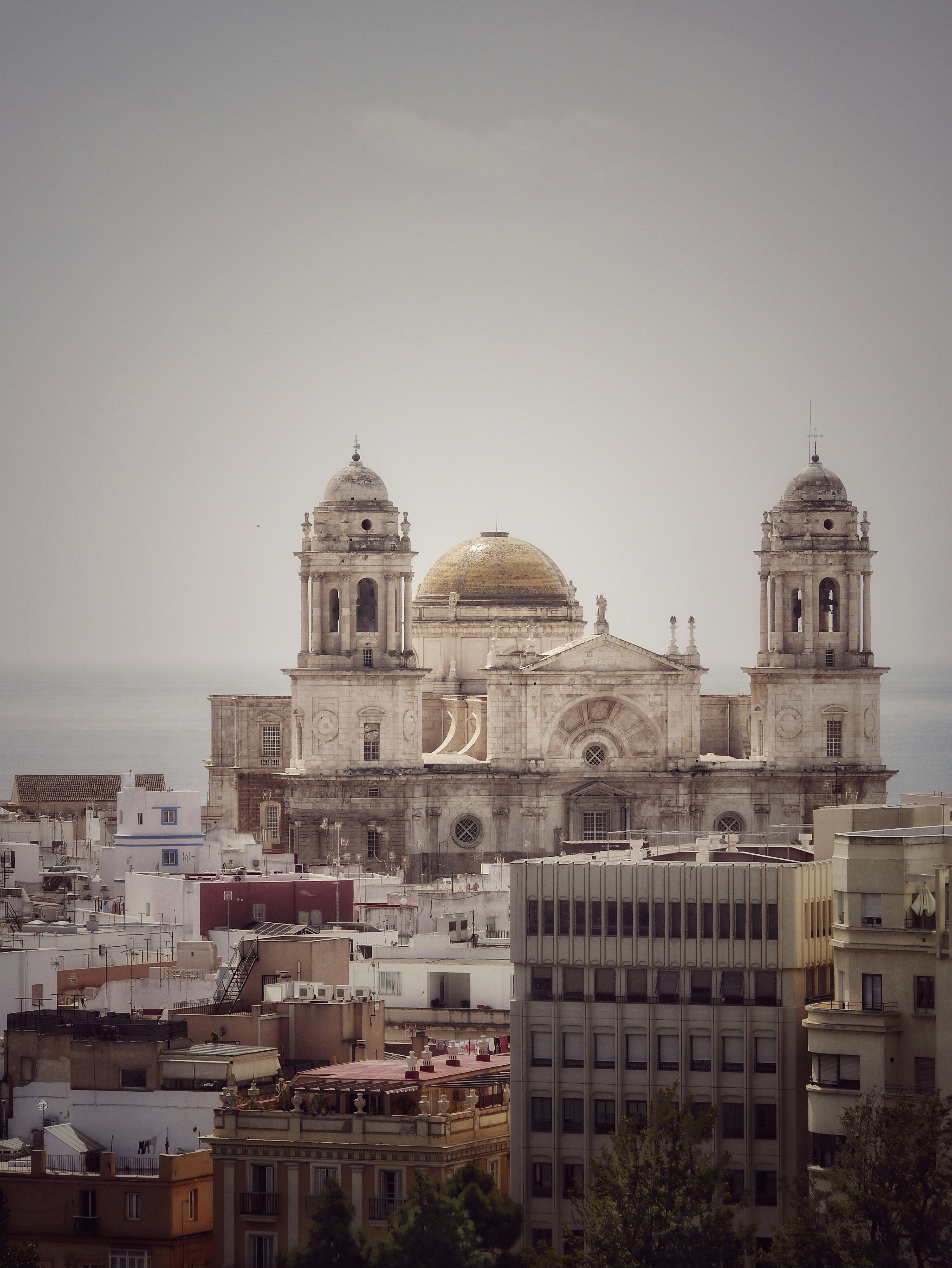 Cathedral silhouette peeking over a sunlit Spanish city