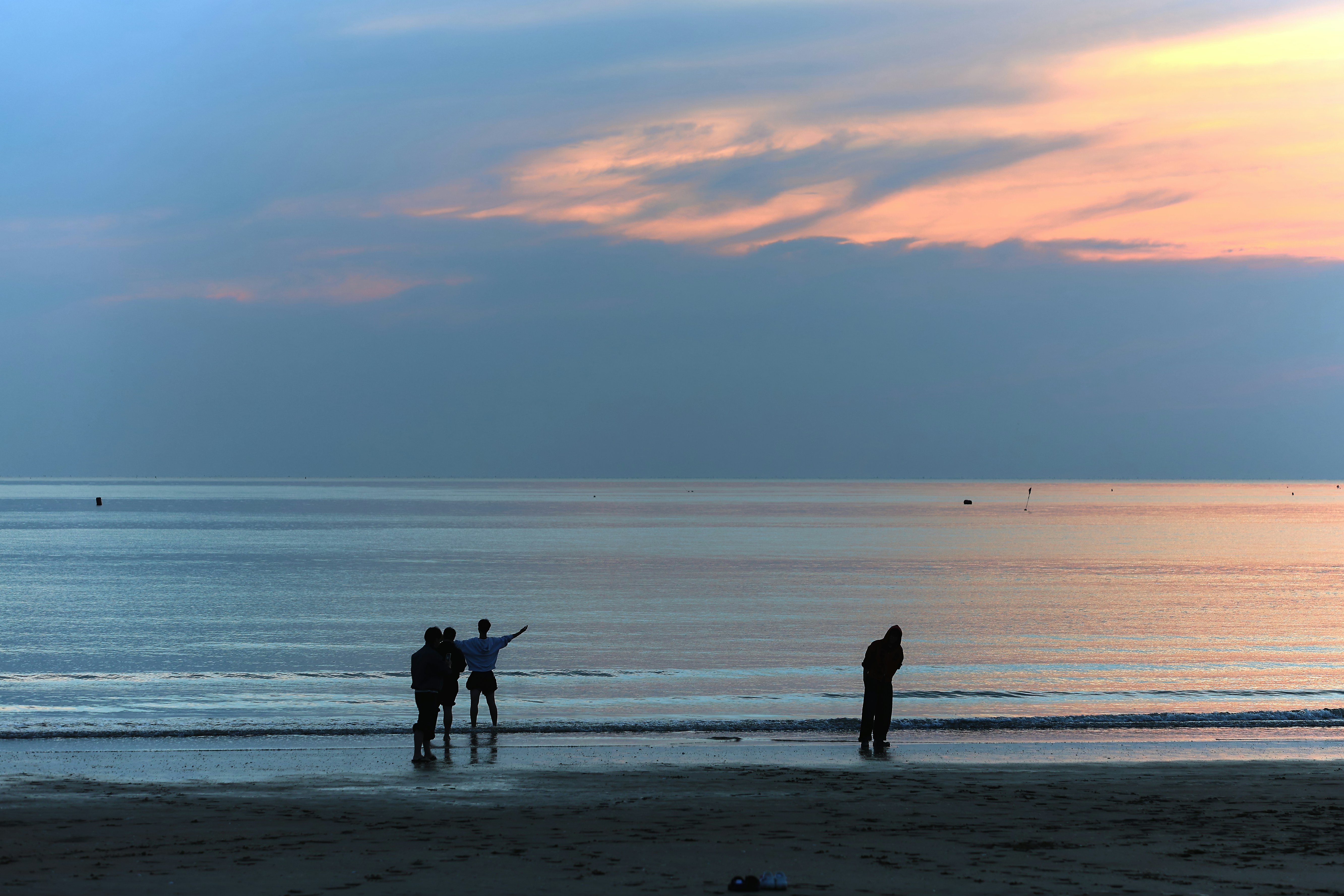 Sunset silhouettes: a small group by the sea