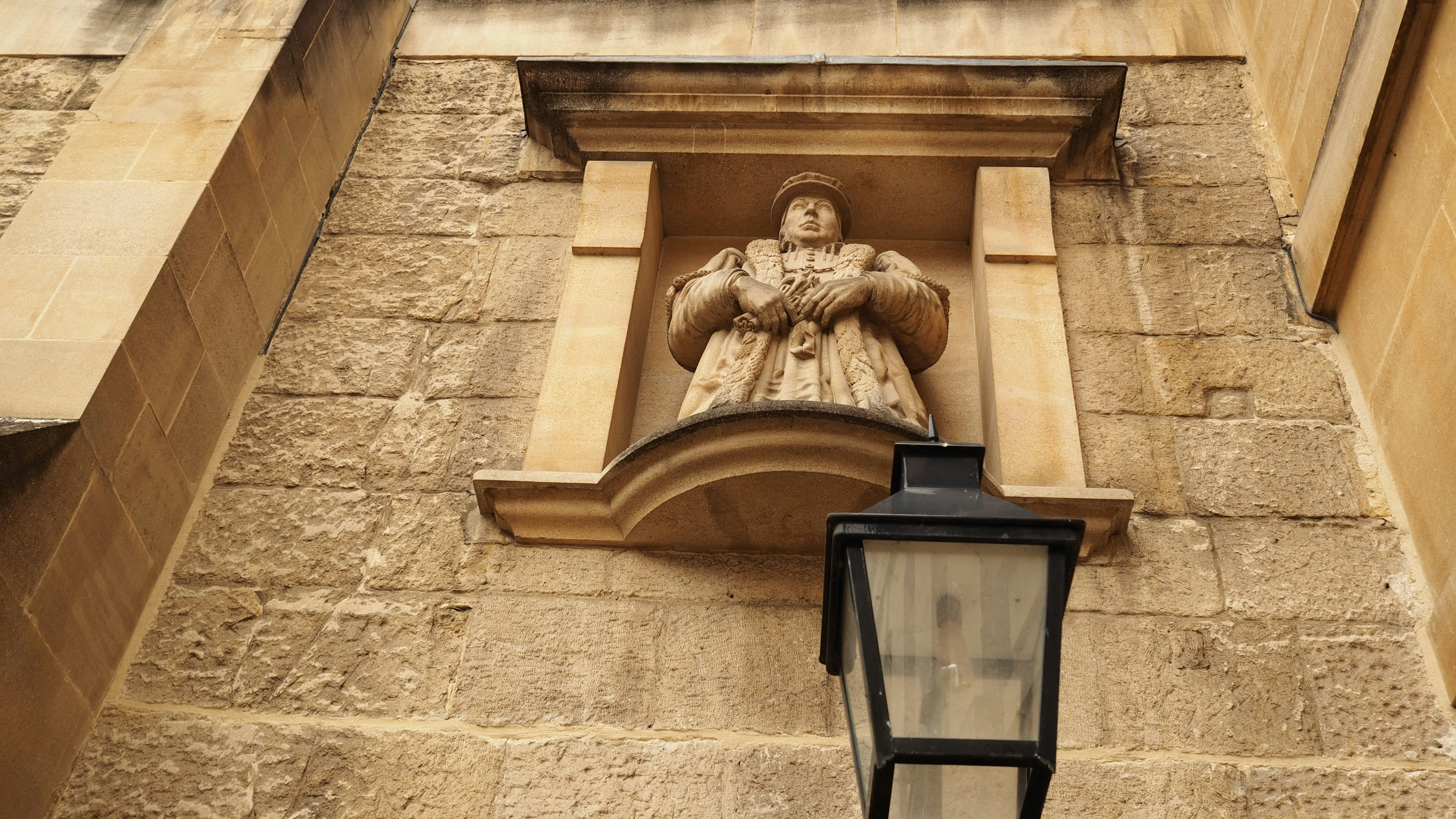 Stone Sentinel: A Classical Statue Framed by a Lantern